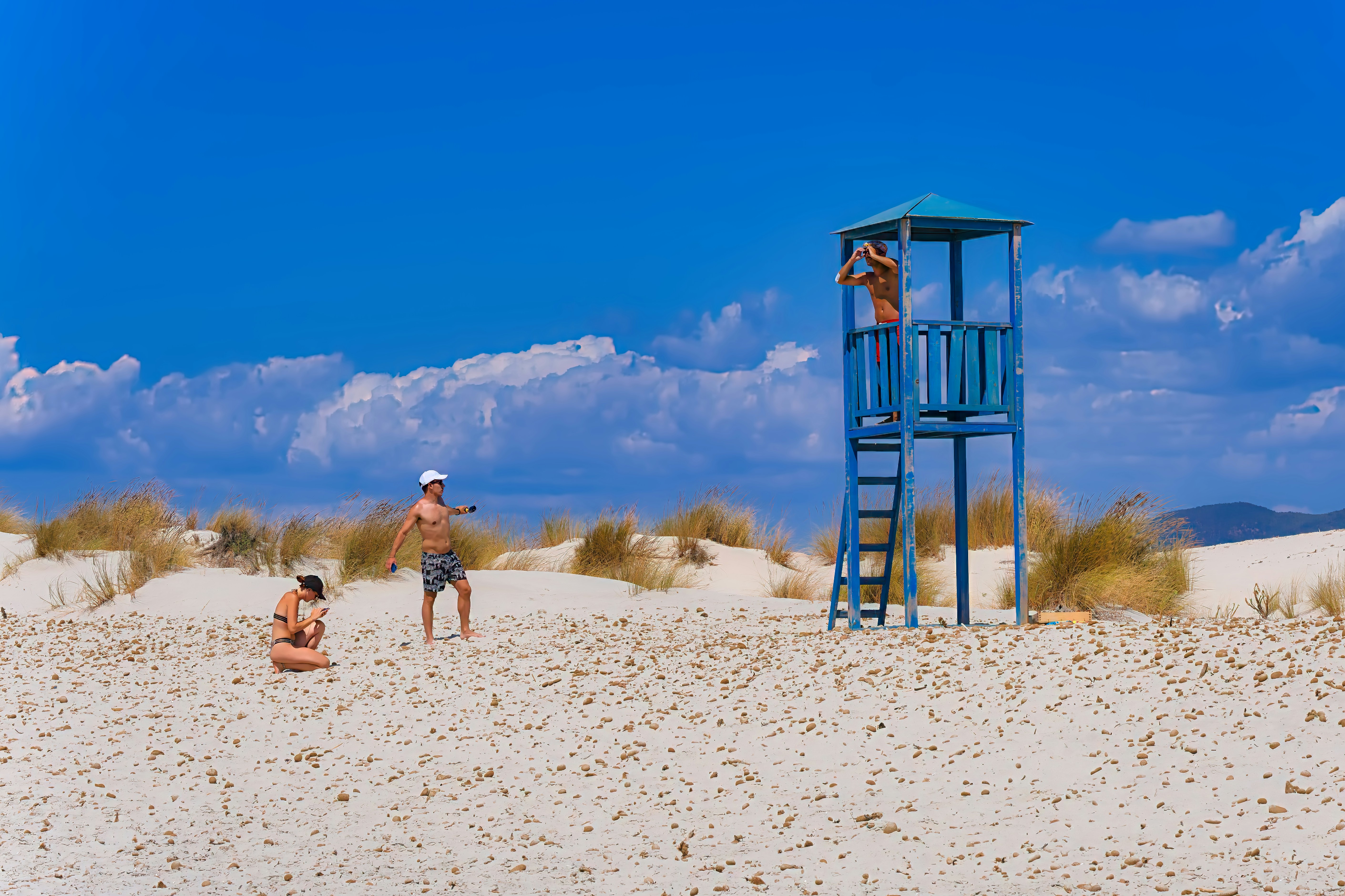 Blue Lifeguard Tower against Wide Dunes and Bright Sky