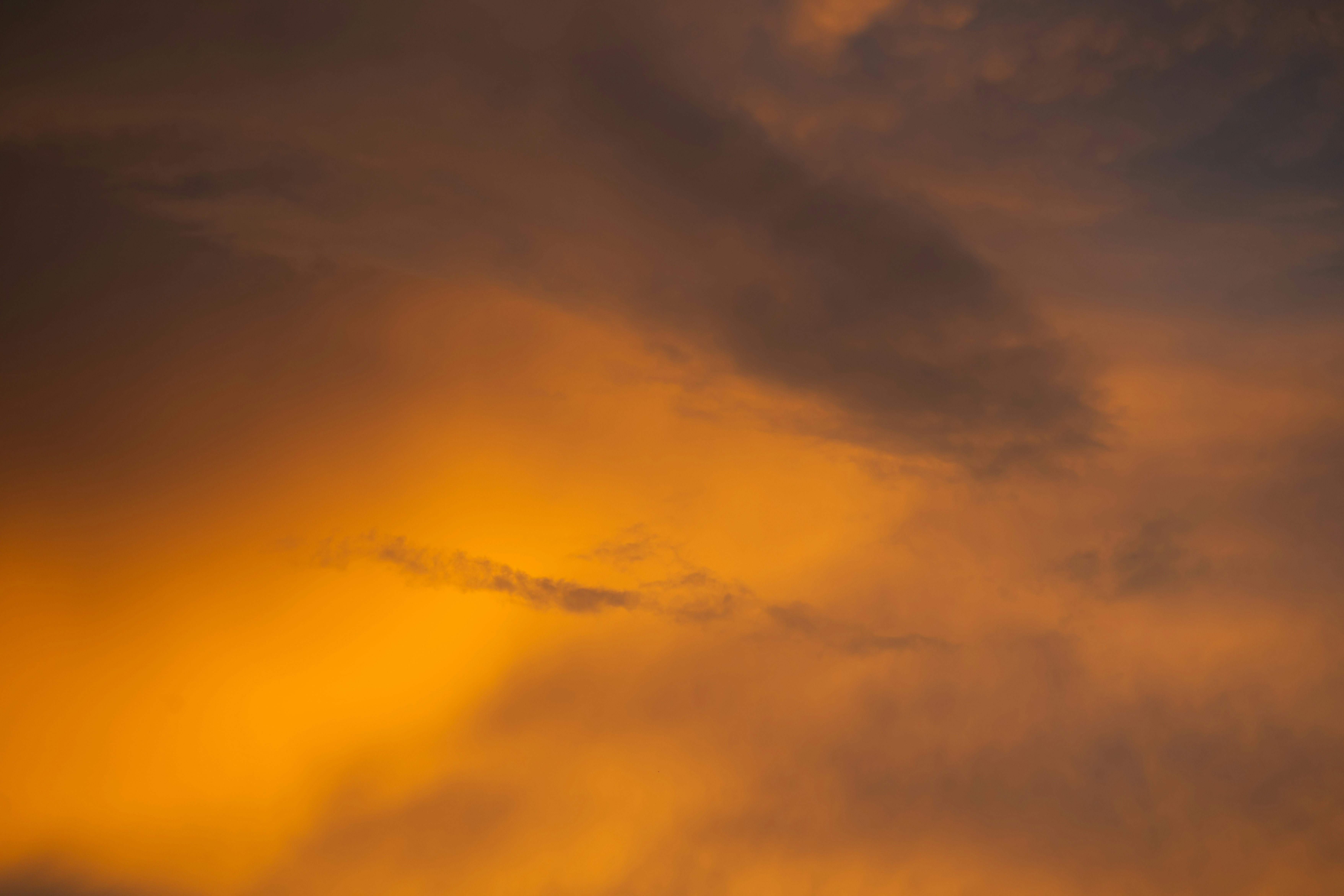 Soft orange clouds drift across a warm sky, conveying calm dawn light and expansive atmosphere without any people or objects.