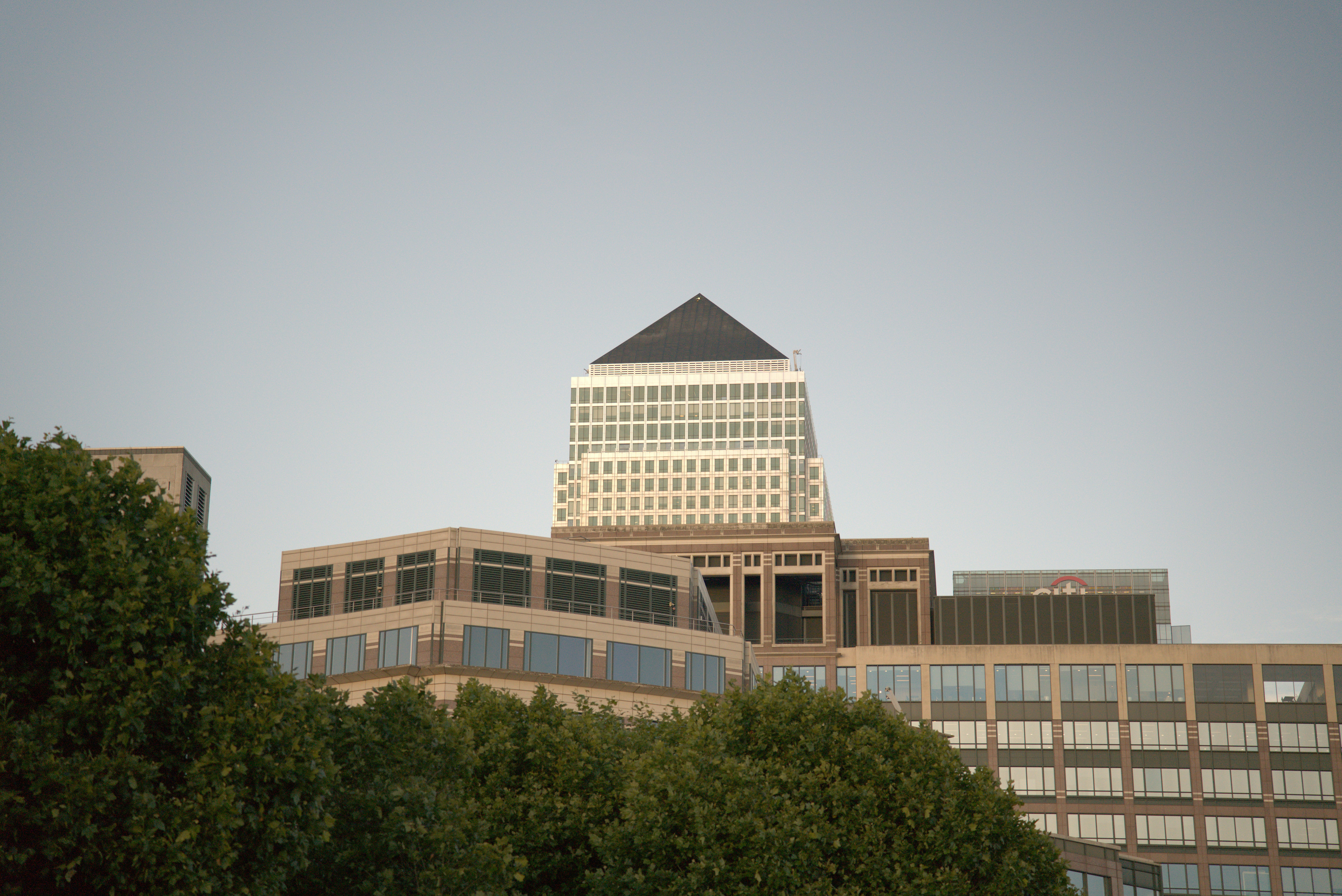 Skyward Facade: Pyramid Rooftop Amid City Silhouette