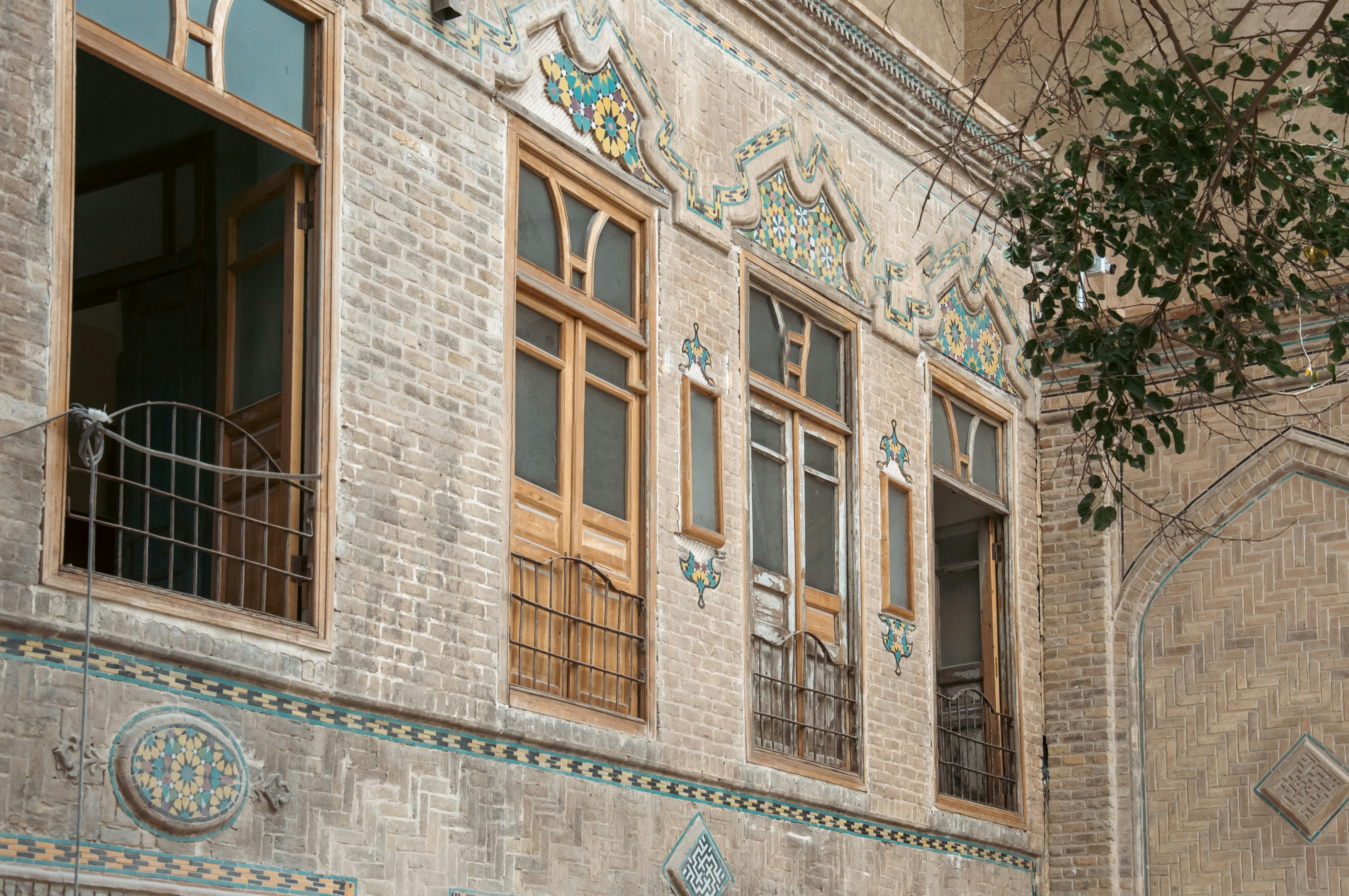 Ornate Brickwork and Wooden Windows on a Persian Facade