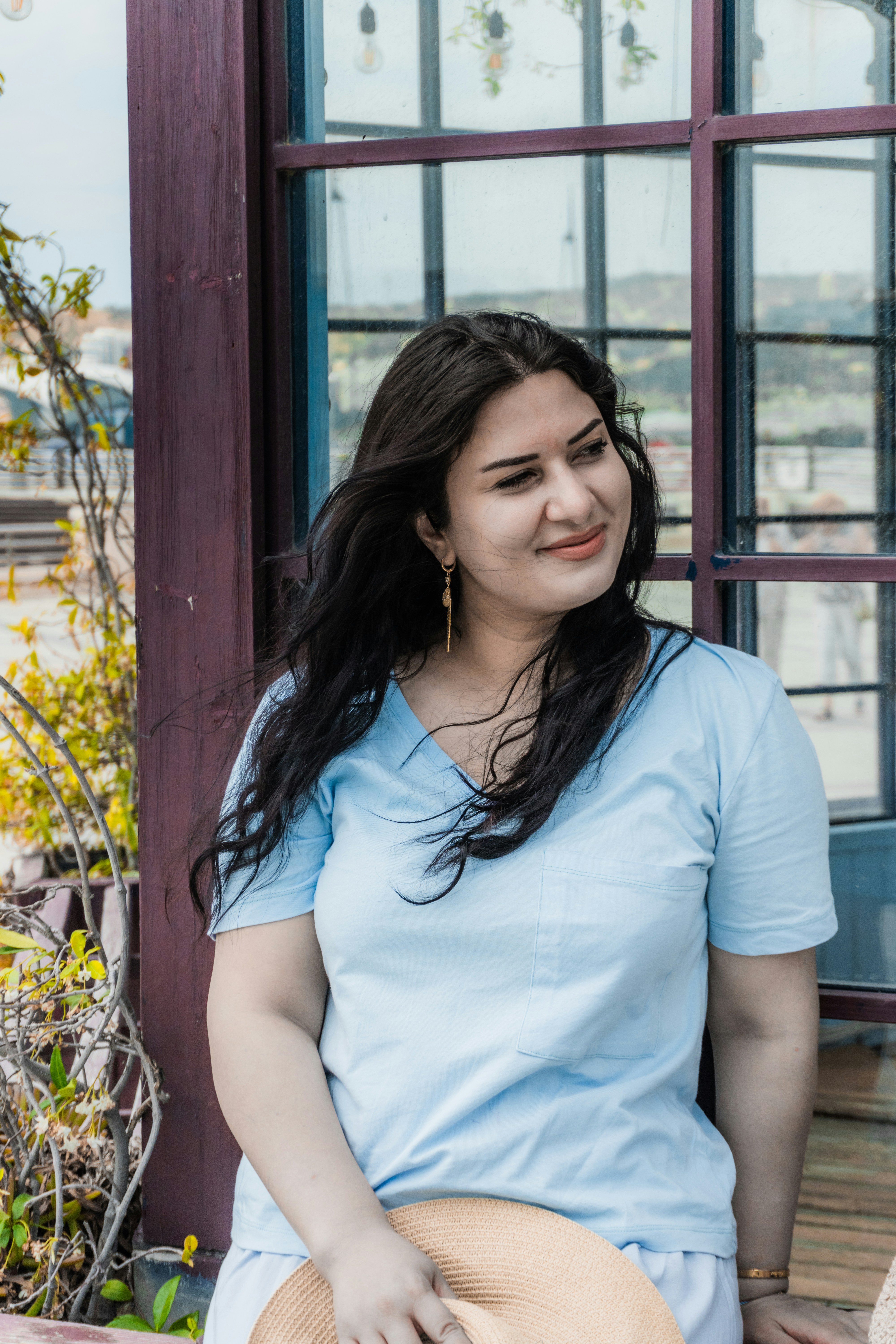 Soft sunlight and calm gaze: a portrait against a glass backdrop