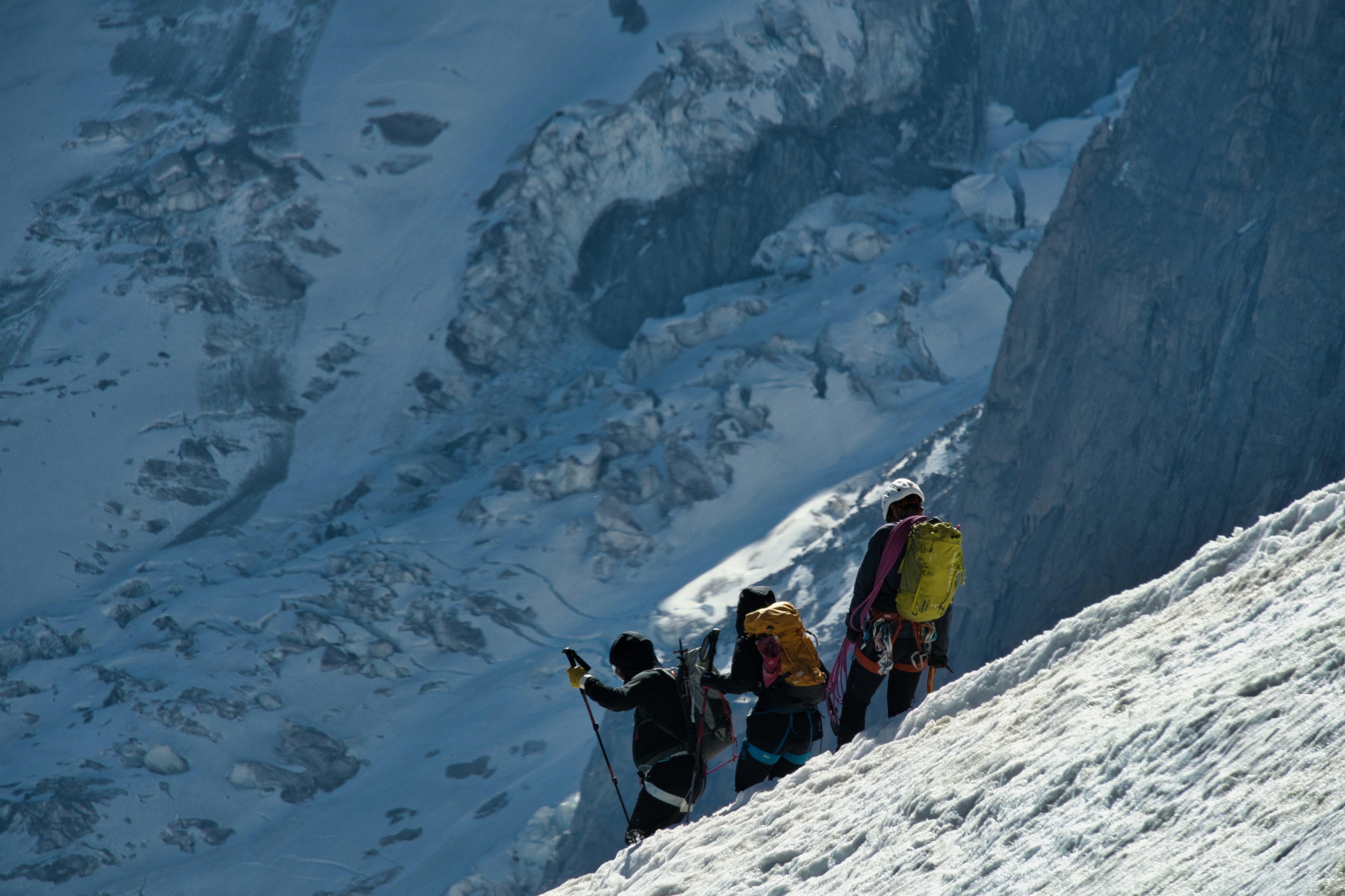 Climbers Thread a Narrow Crest Under Alpine Giants