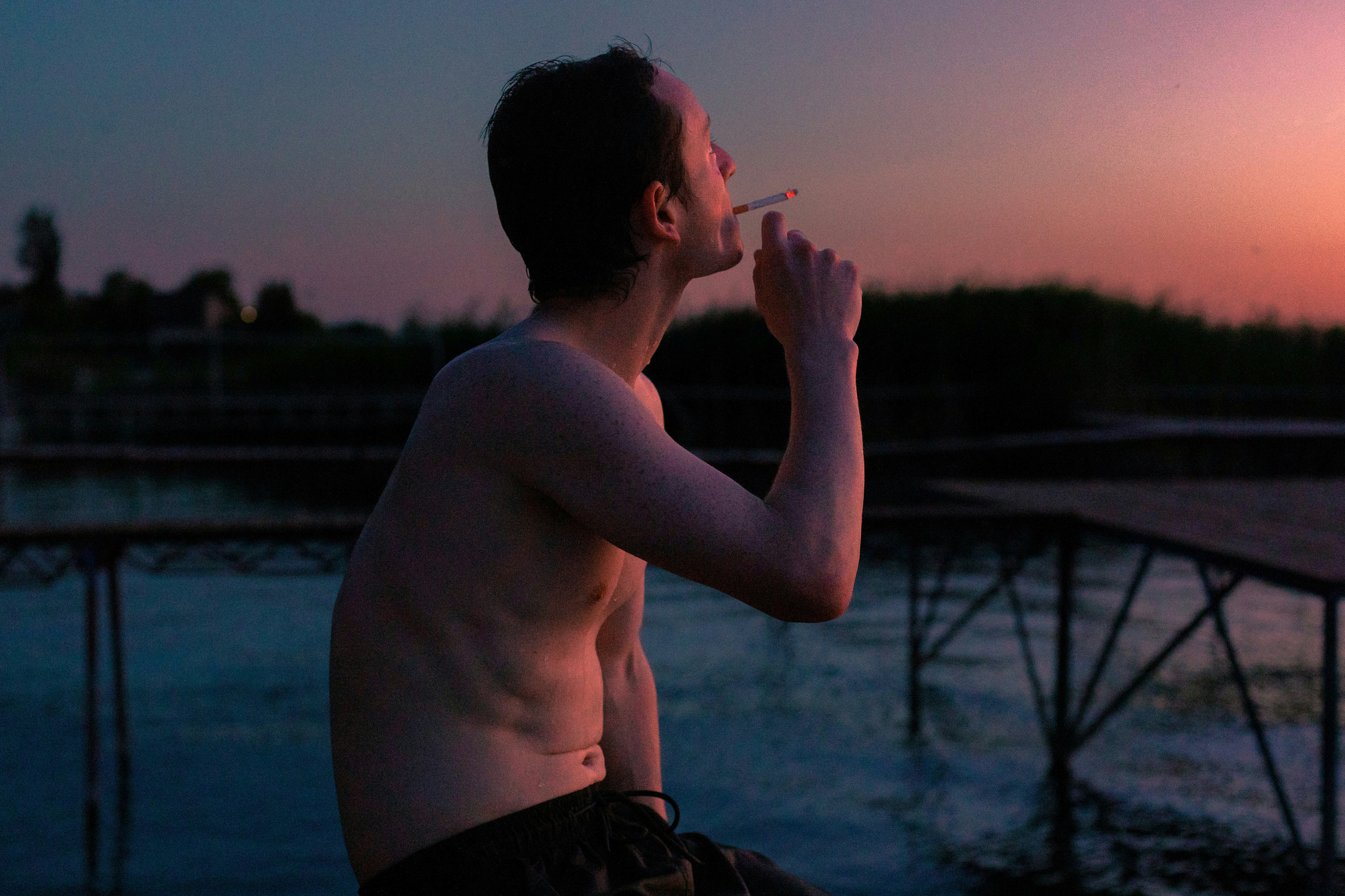 Cigarette at Dusk: A Quiet Moment on the Dock