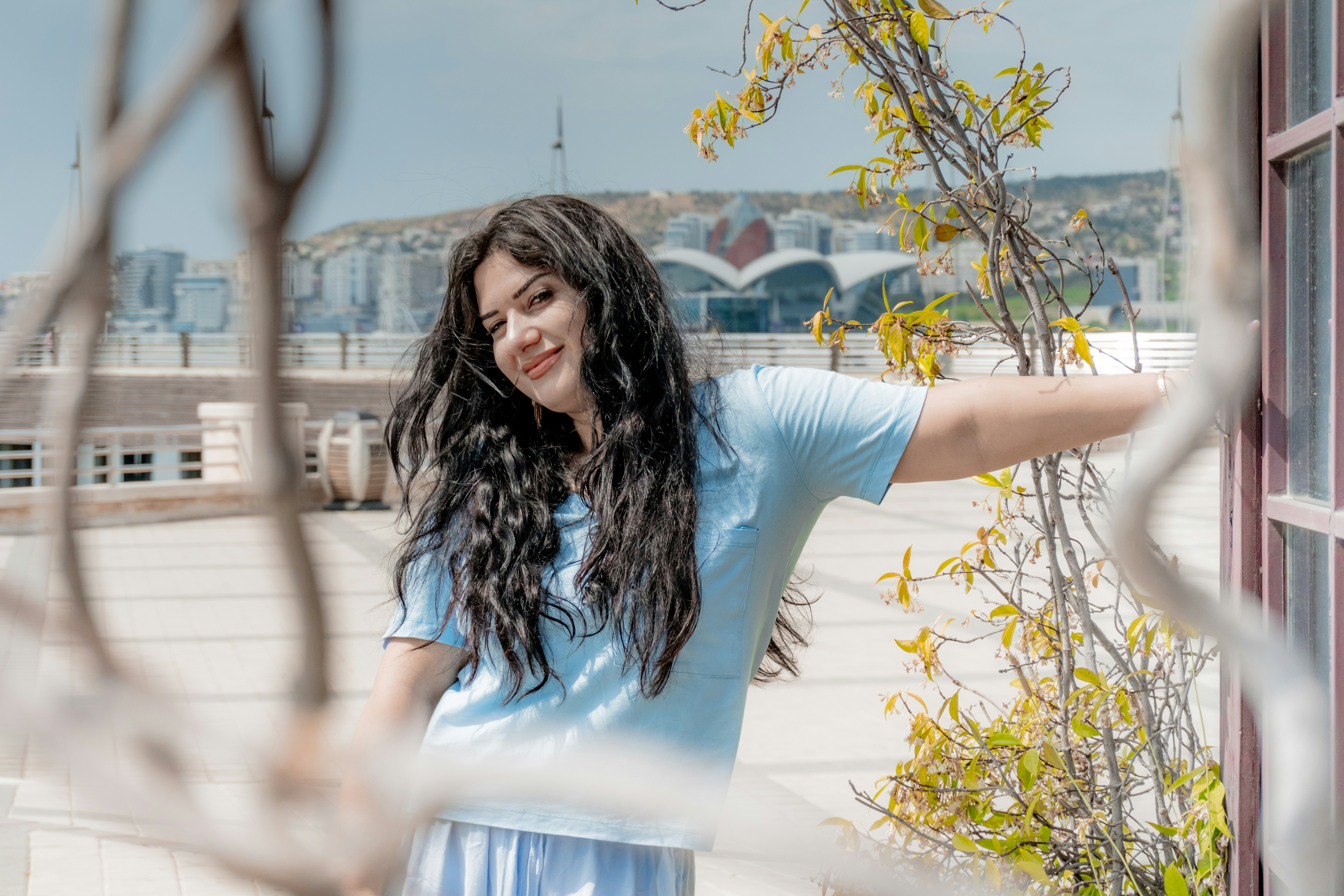 Sunlit Terrace Portrait: A Smile Amid Arching Branches