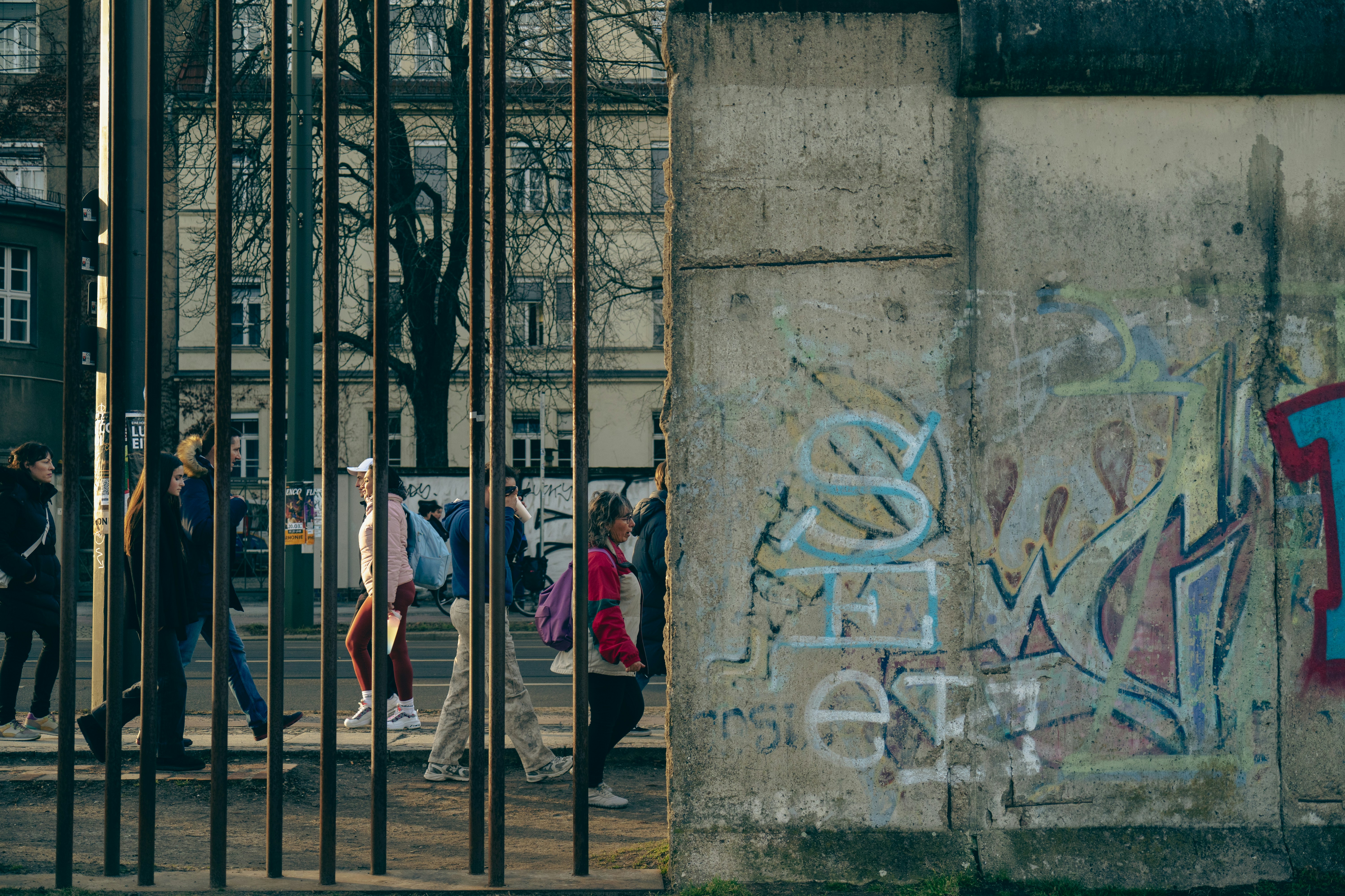 Passing Faces: A Line of Travelers Along a Graffitied Wall