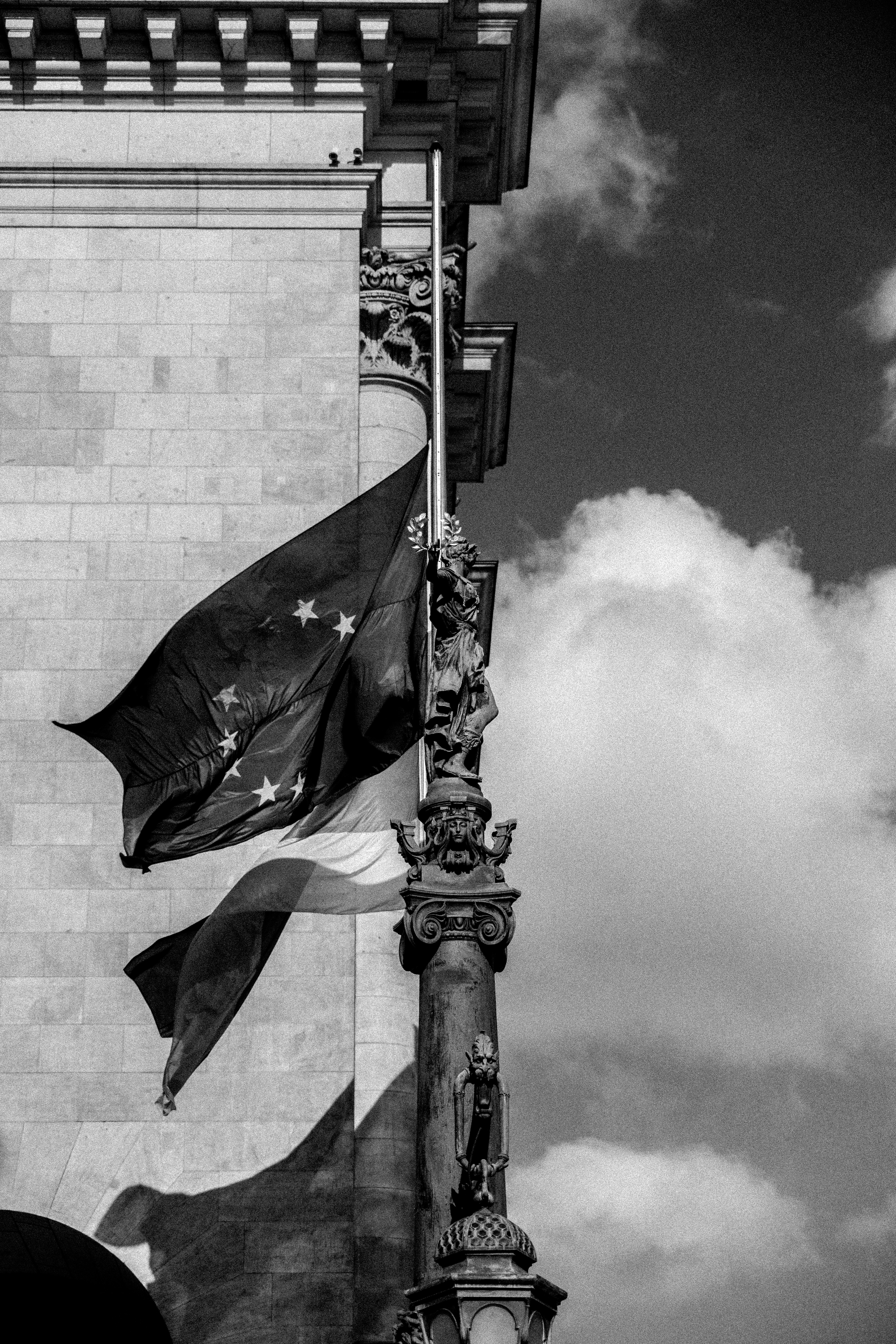 European union flag and another flag on a classical building.