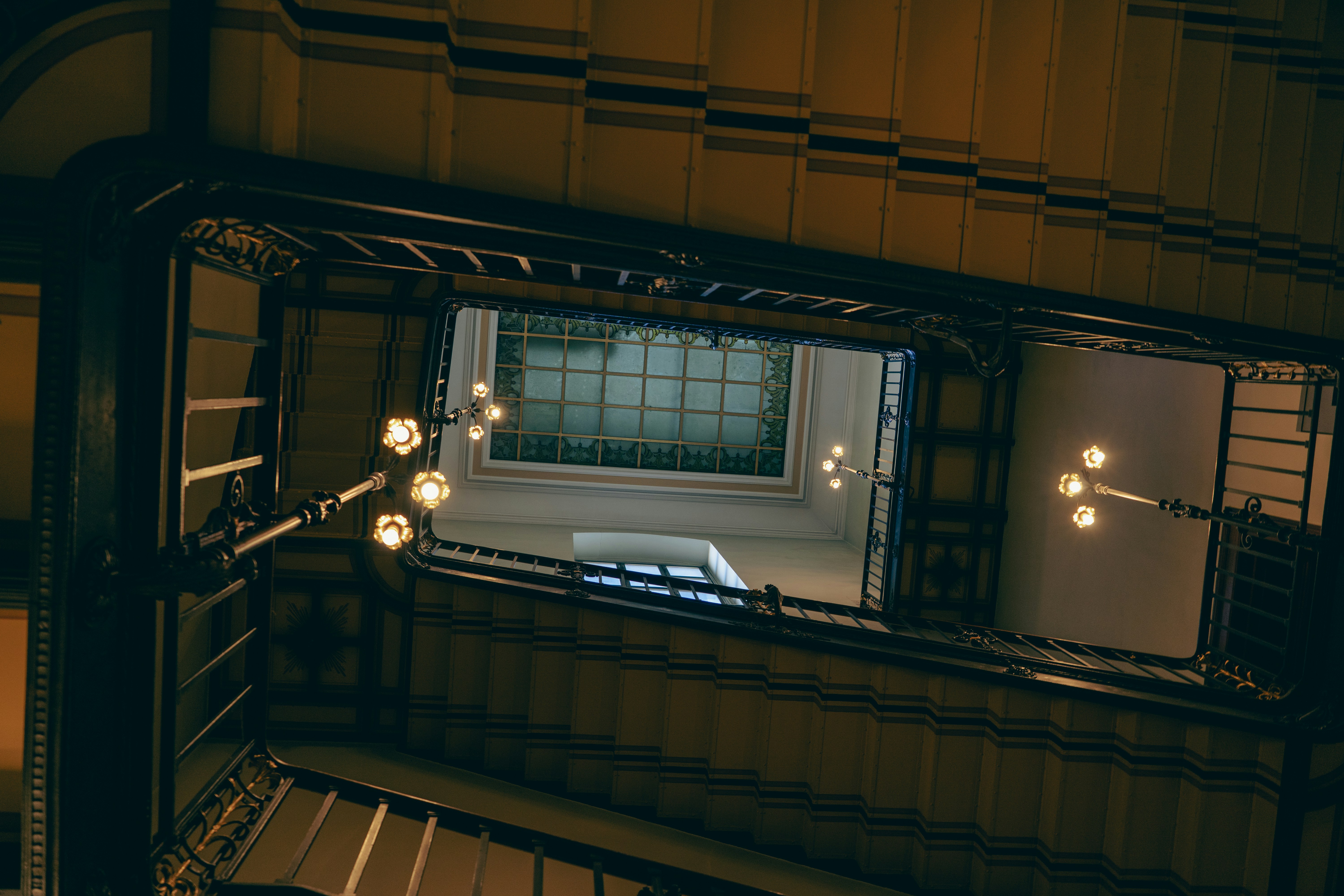 Overhead Lanterns Framing a Vertical Atrium Staircase