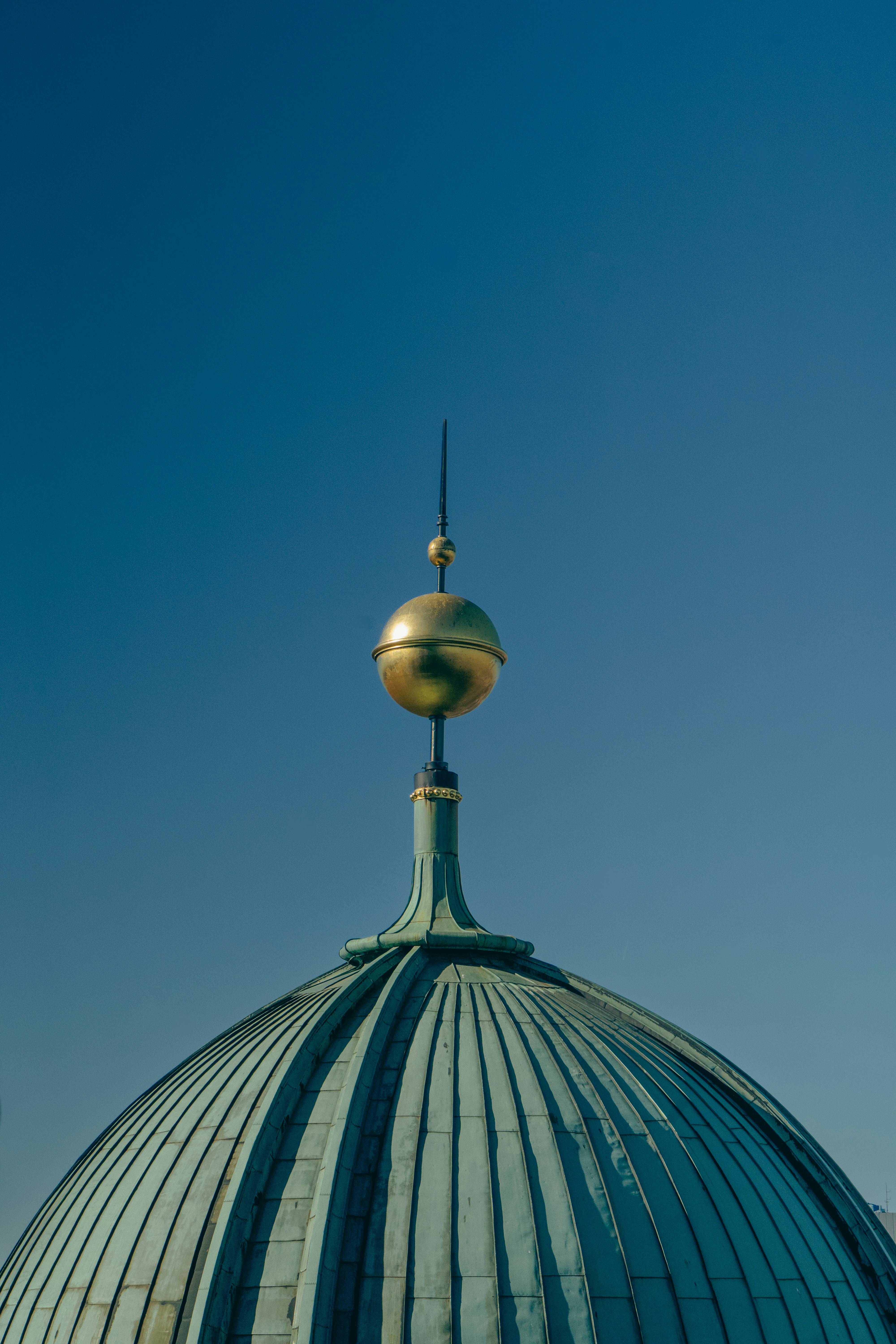Golden Sphere Crowned Spire Rising from a Seamless Dome