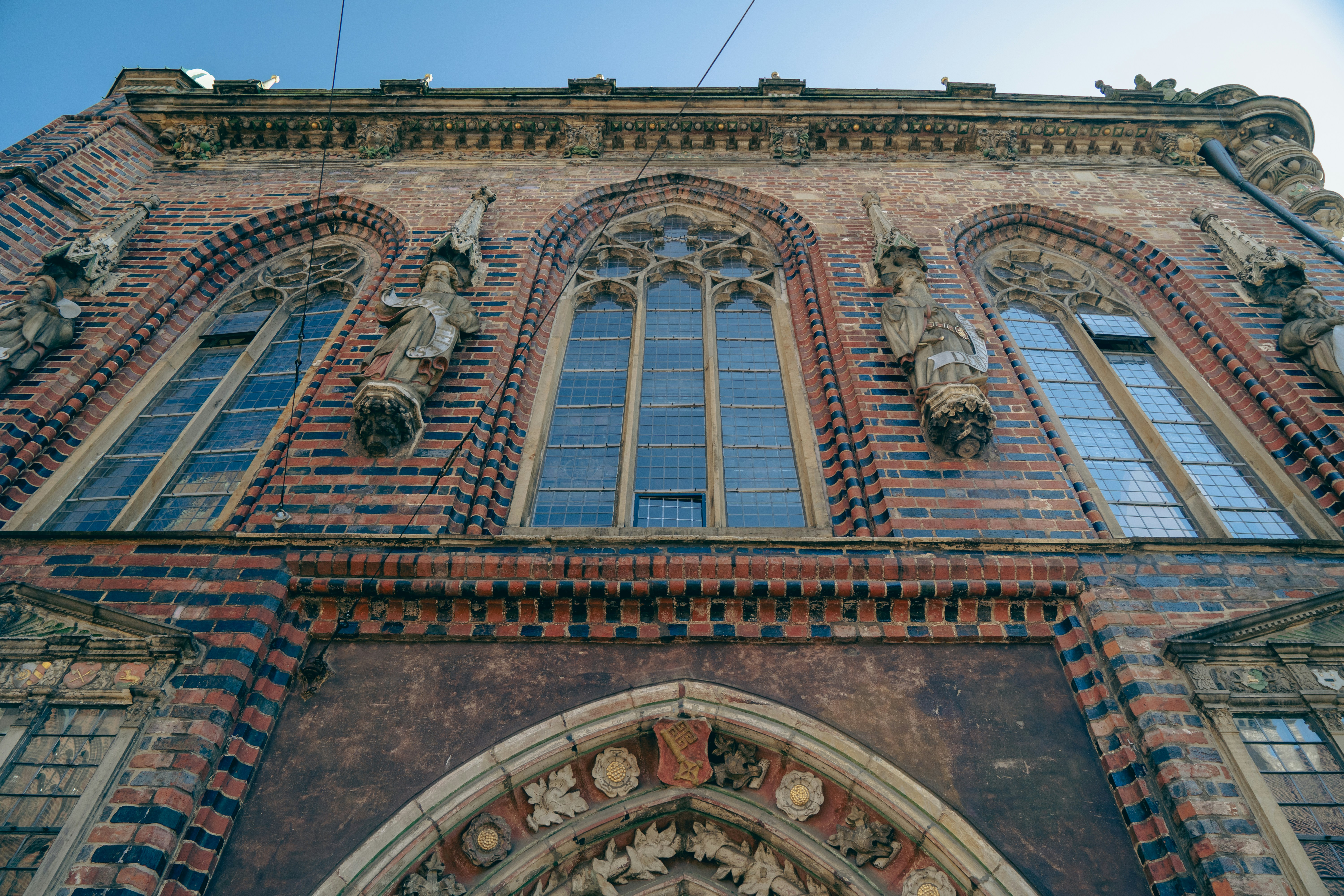 Brick Gothic Facade with Arched Windows and Sunlit Detailing