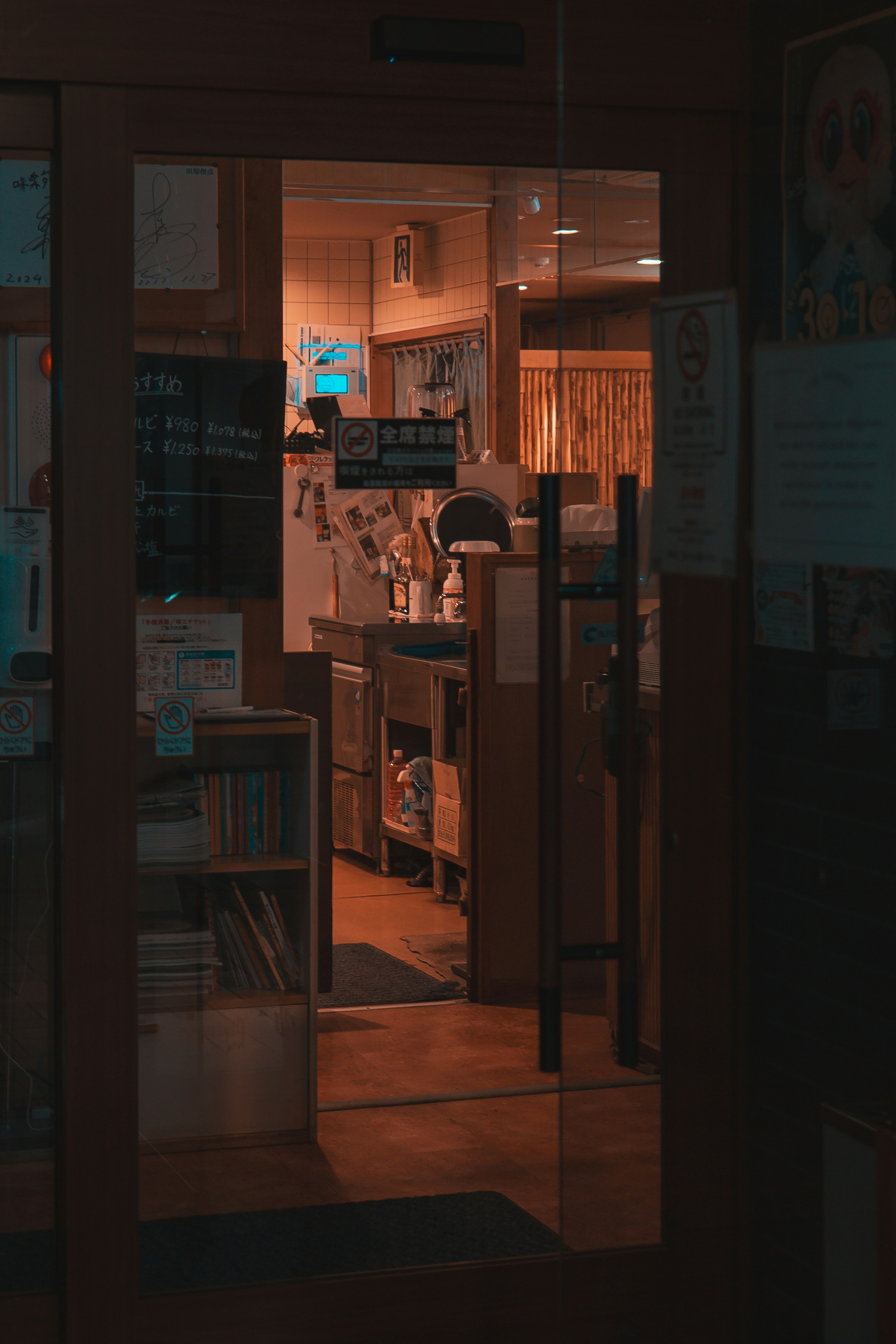 Soft Warm Threshold: A Dusk-Illuminated Store Kitchen Through Glass Doors
