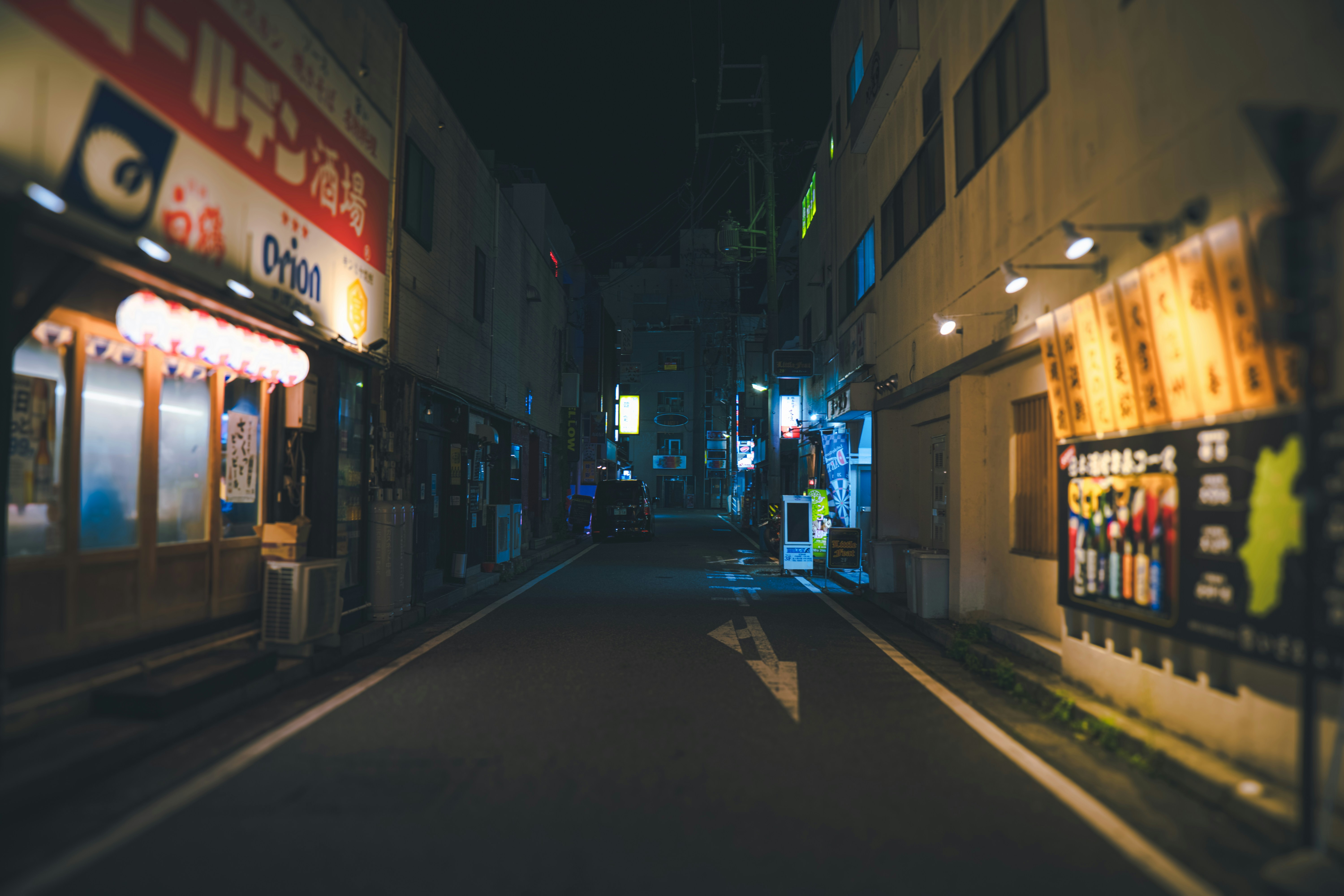 Night Street Pulse: Neon-Lit Alleyway Towards the Distant Blue Light