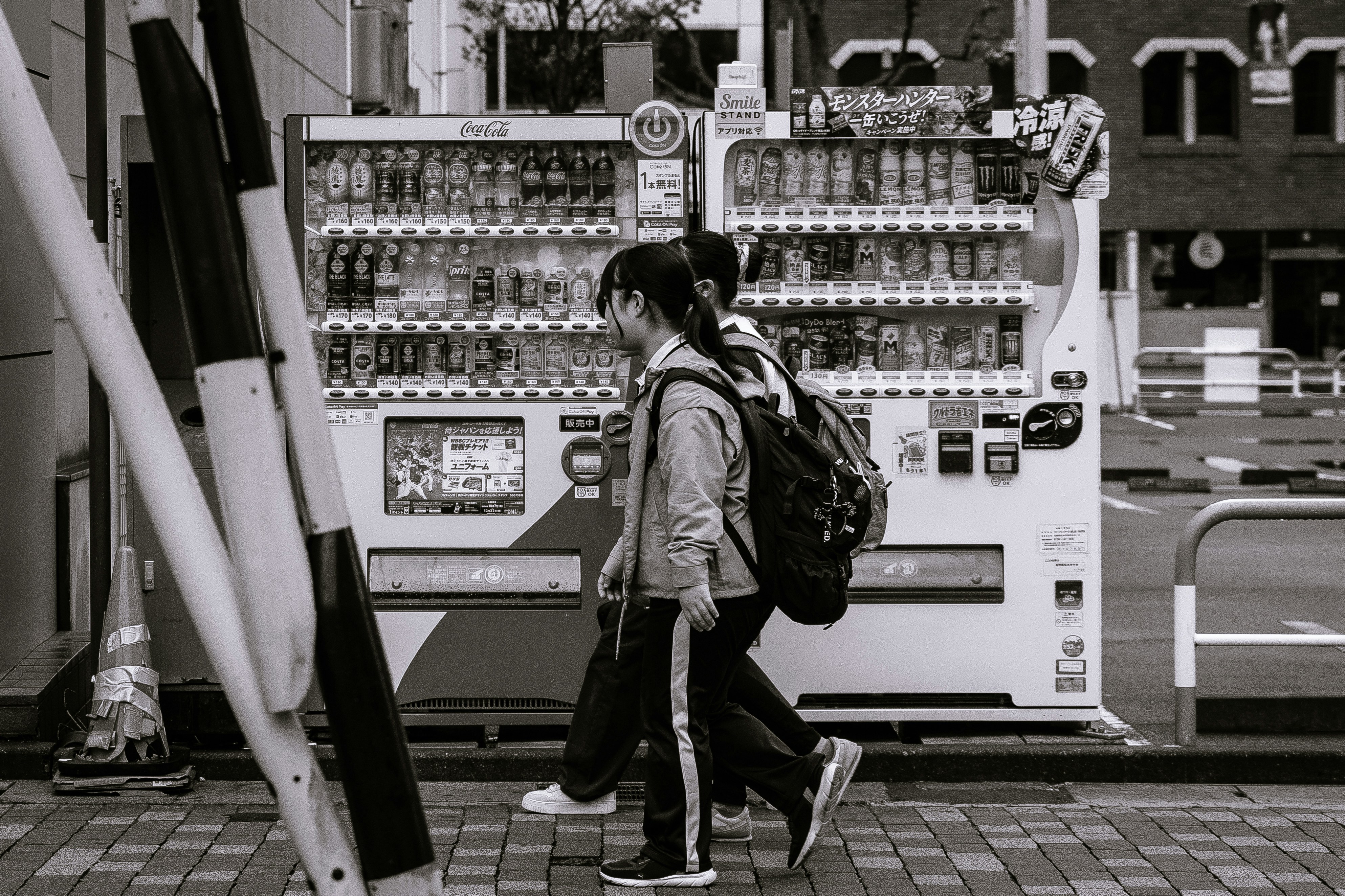 Two Schoolwalkers in a Quiet Urban Vending Corridor