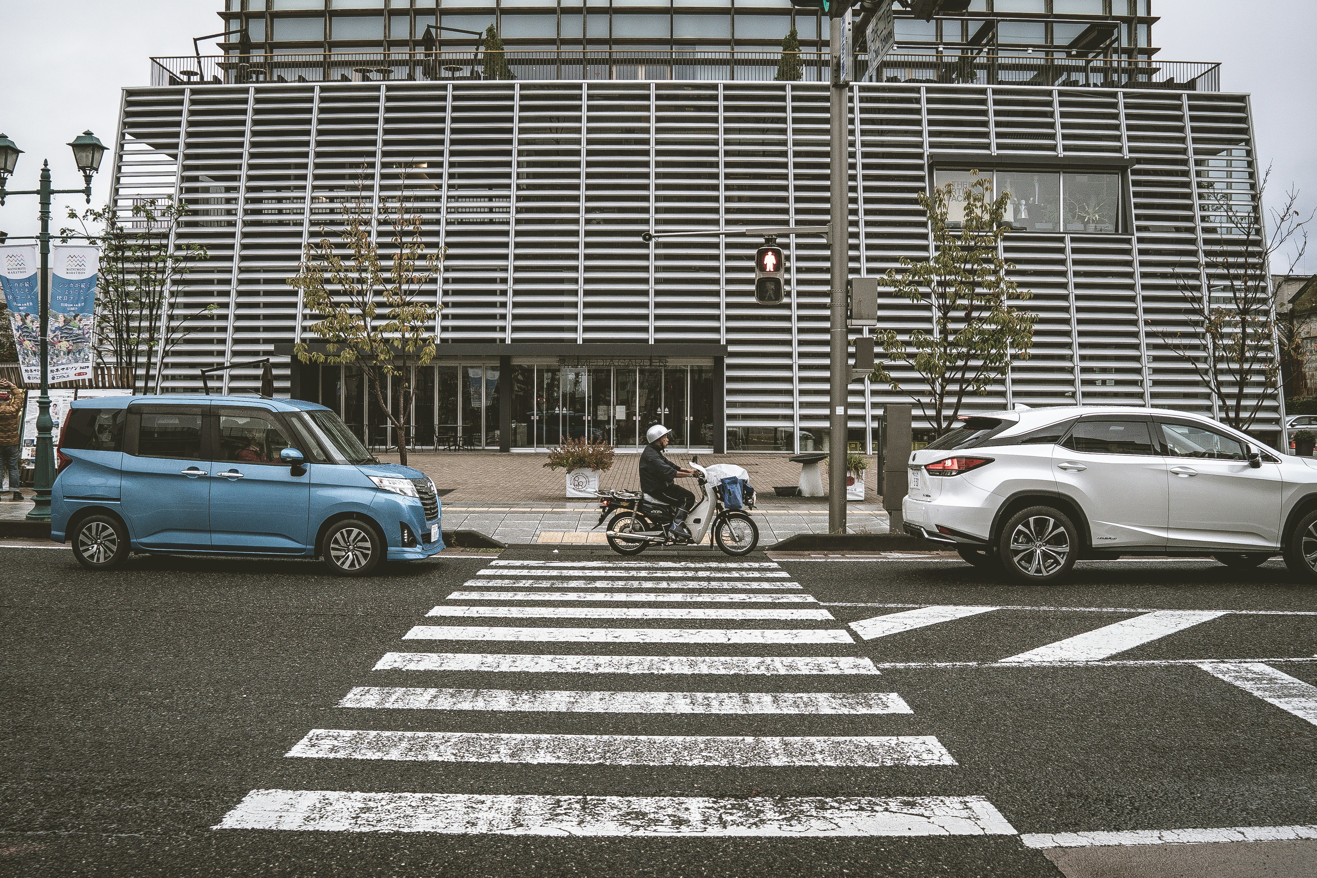 Crosswalk Pulse: A Quiet City Moment in Front of a Modern Facade