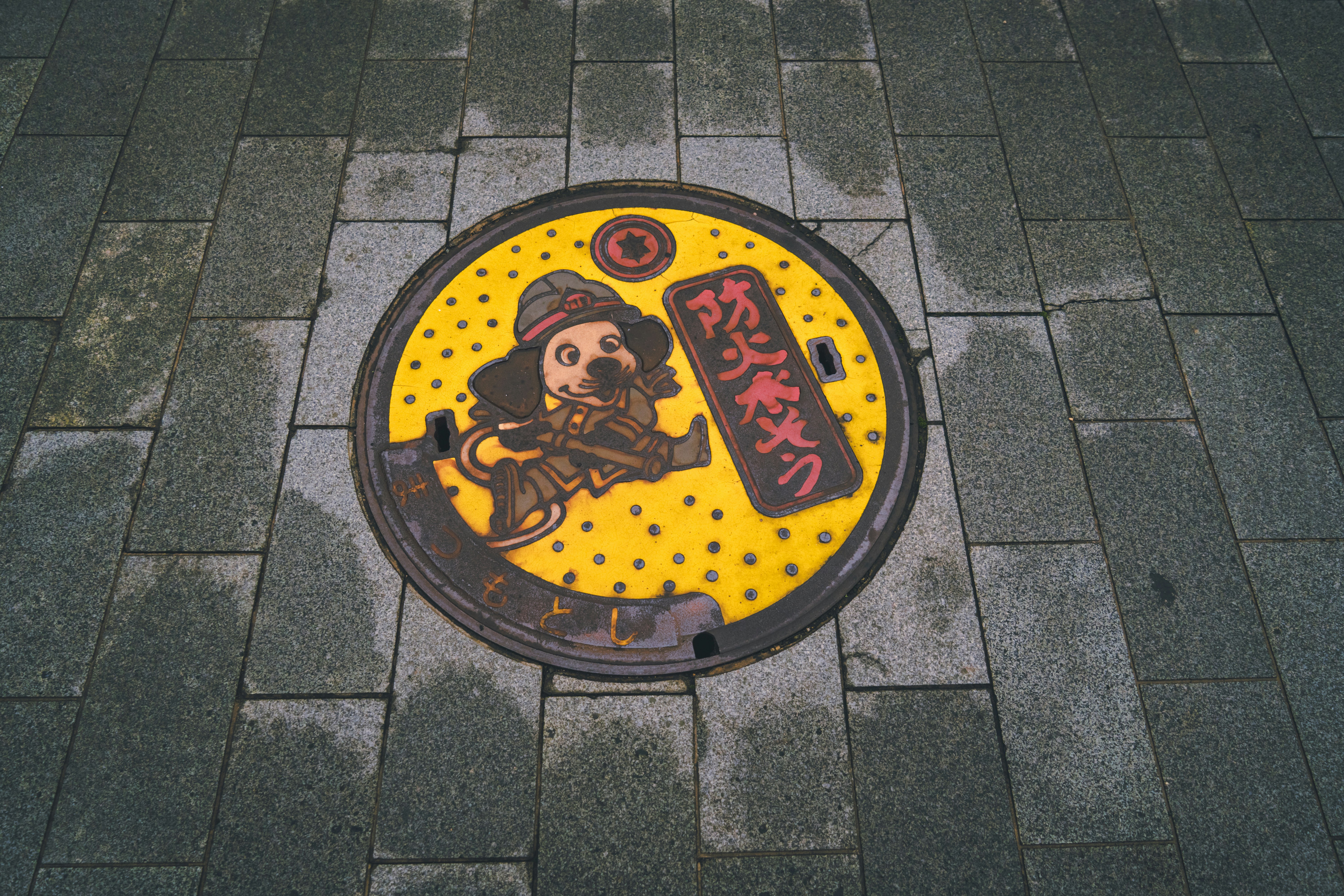 Cartoon Monkey on a Yellow Manhole Cover in a Paved Street