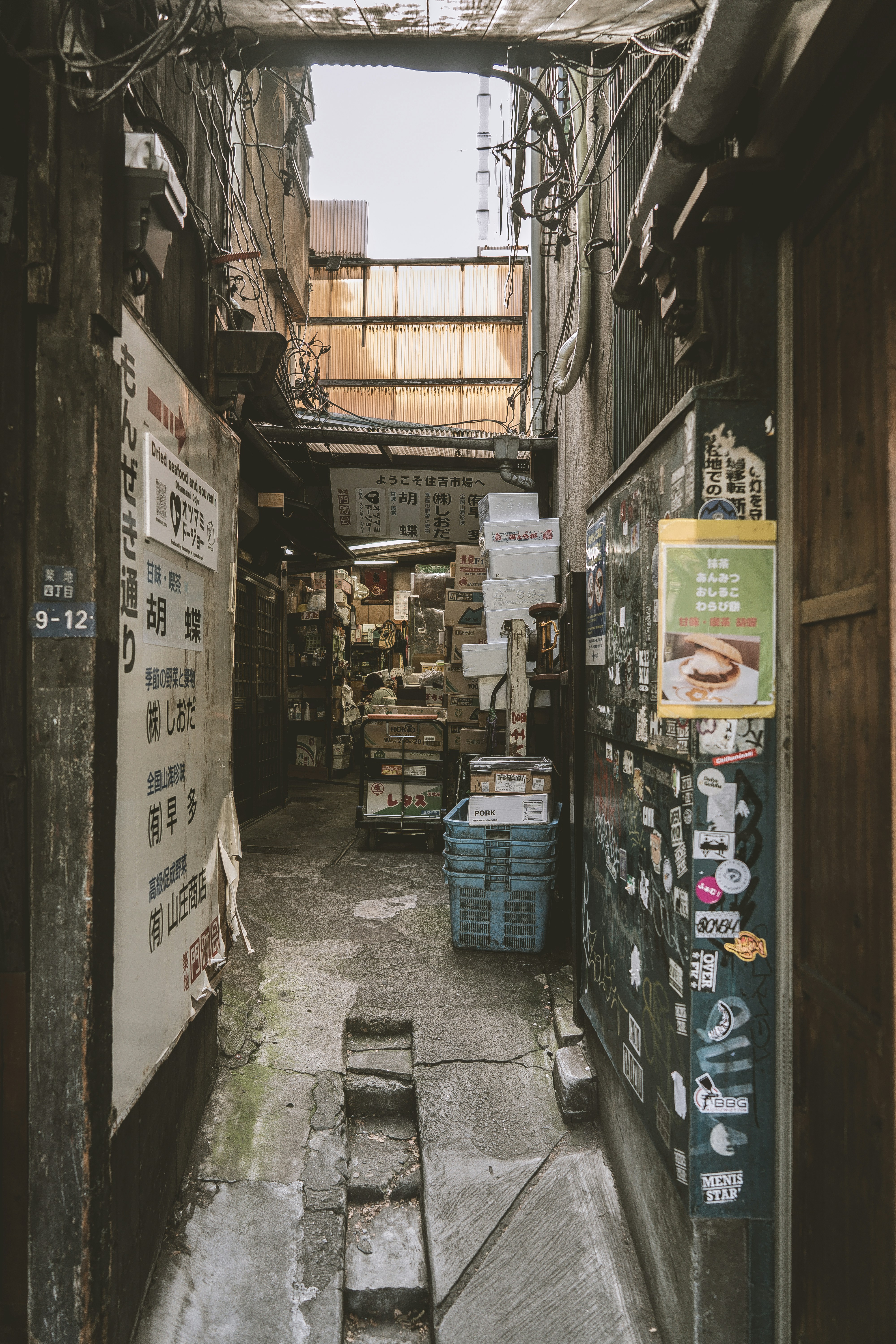 Narrow Market Corridor: Stacks, Signs, and Evening Glow
