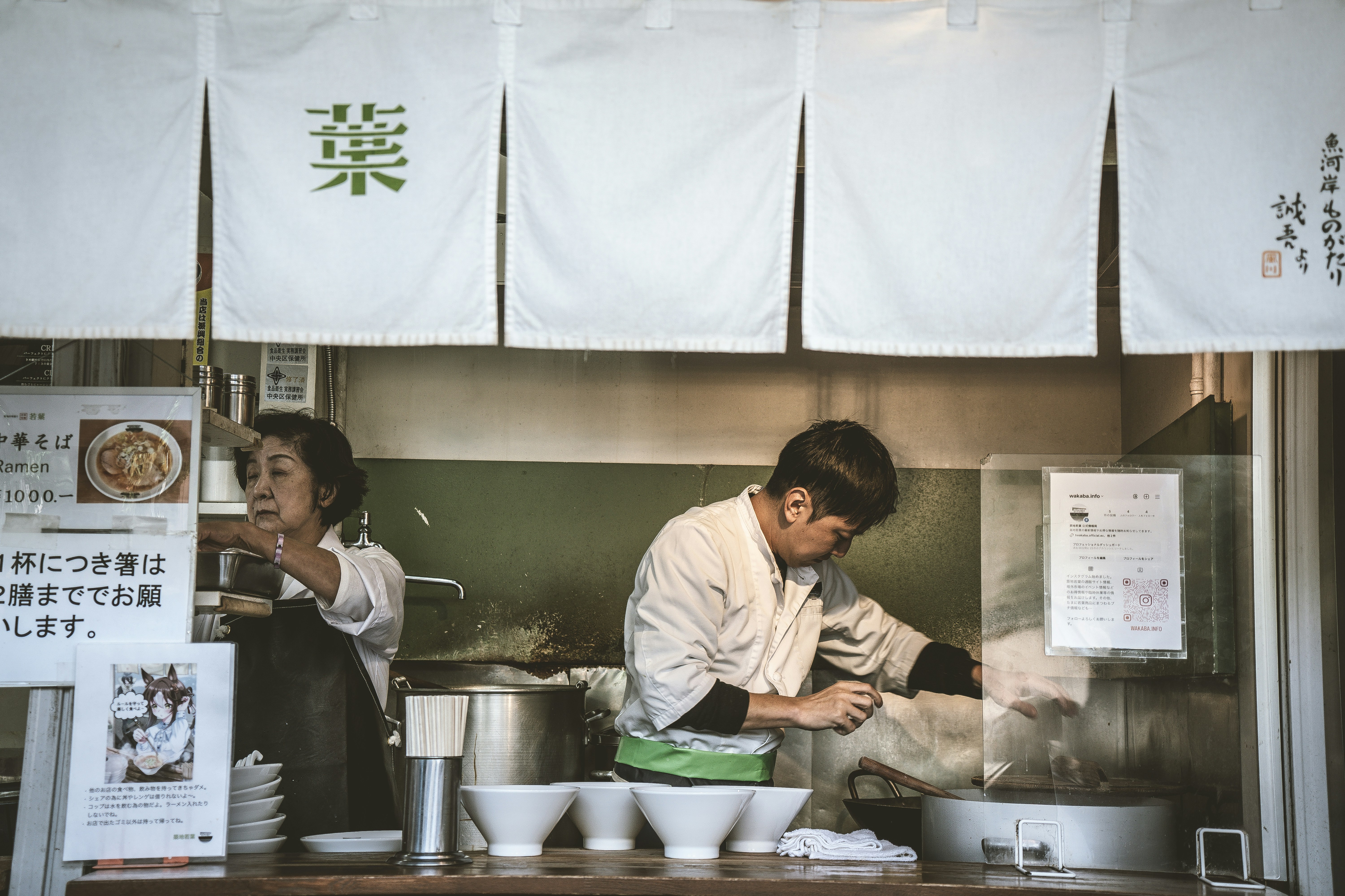 Sushi Stand in Focus: Chef at Work Amid Steam and White Curtains