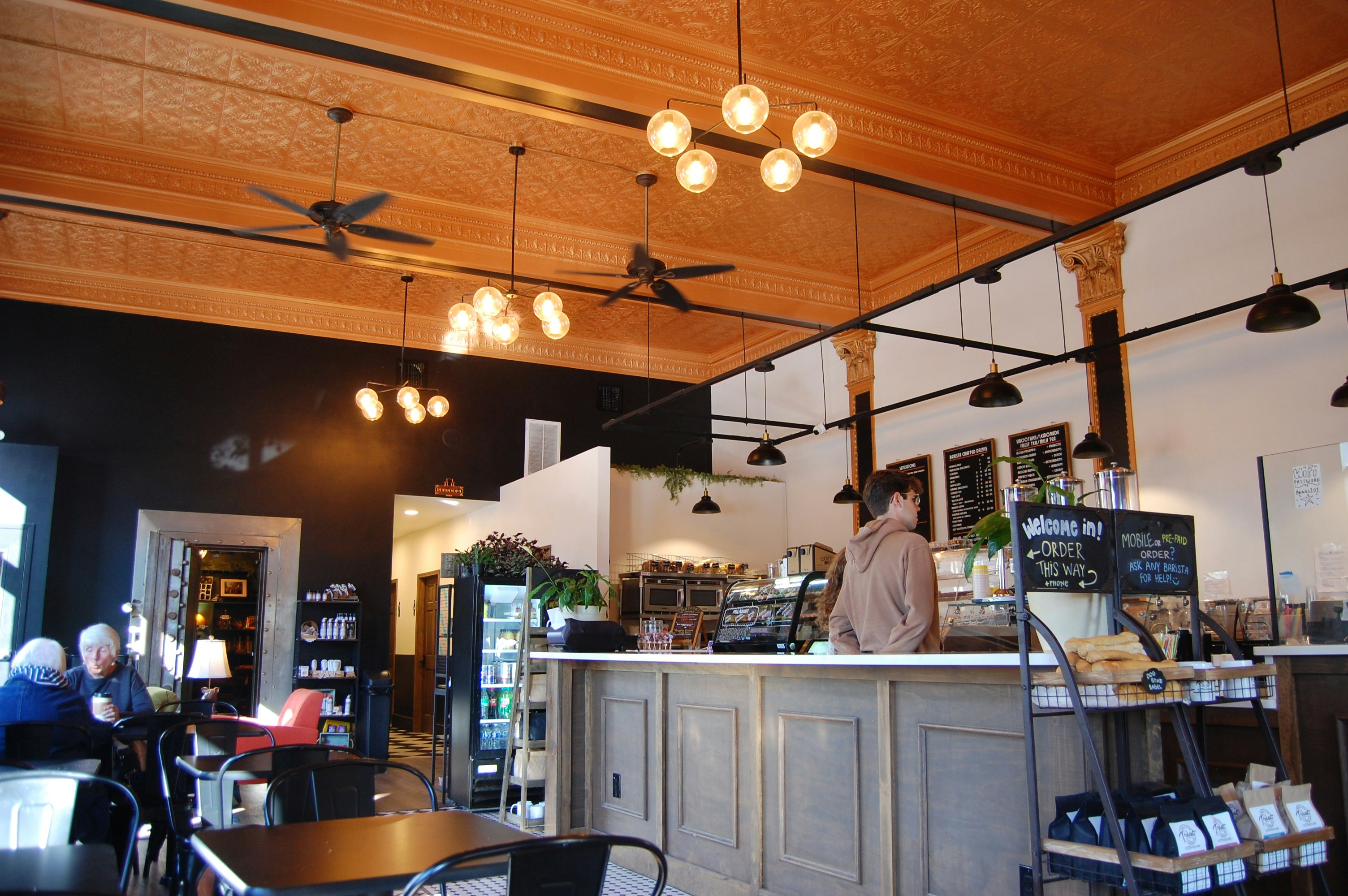 Warm Café Counter with Hanging Lights and Patrons