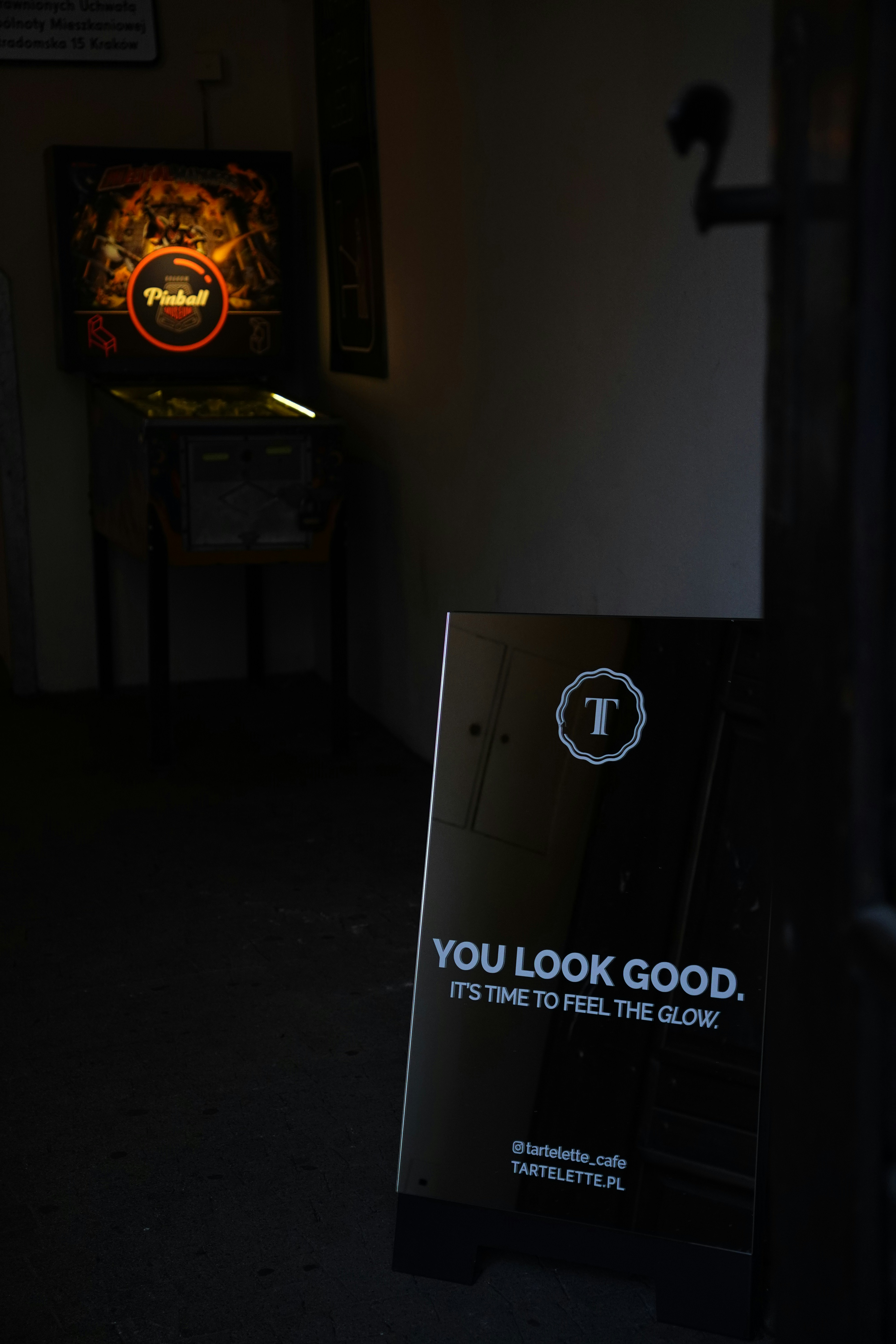 Glow and Shadow: A Neon Sign Beyond a Darkened Entrance
