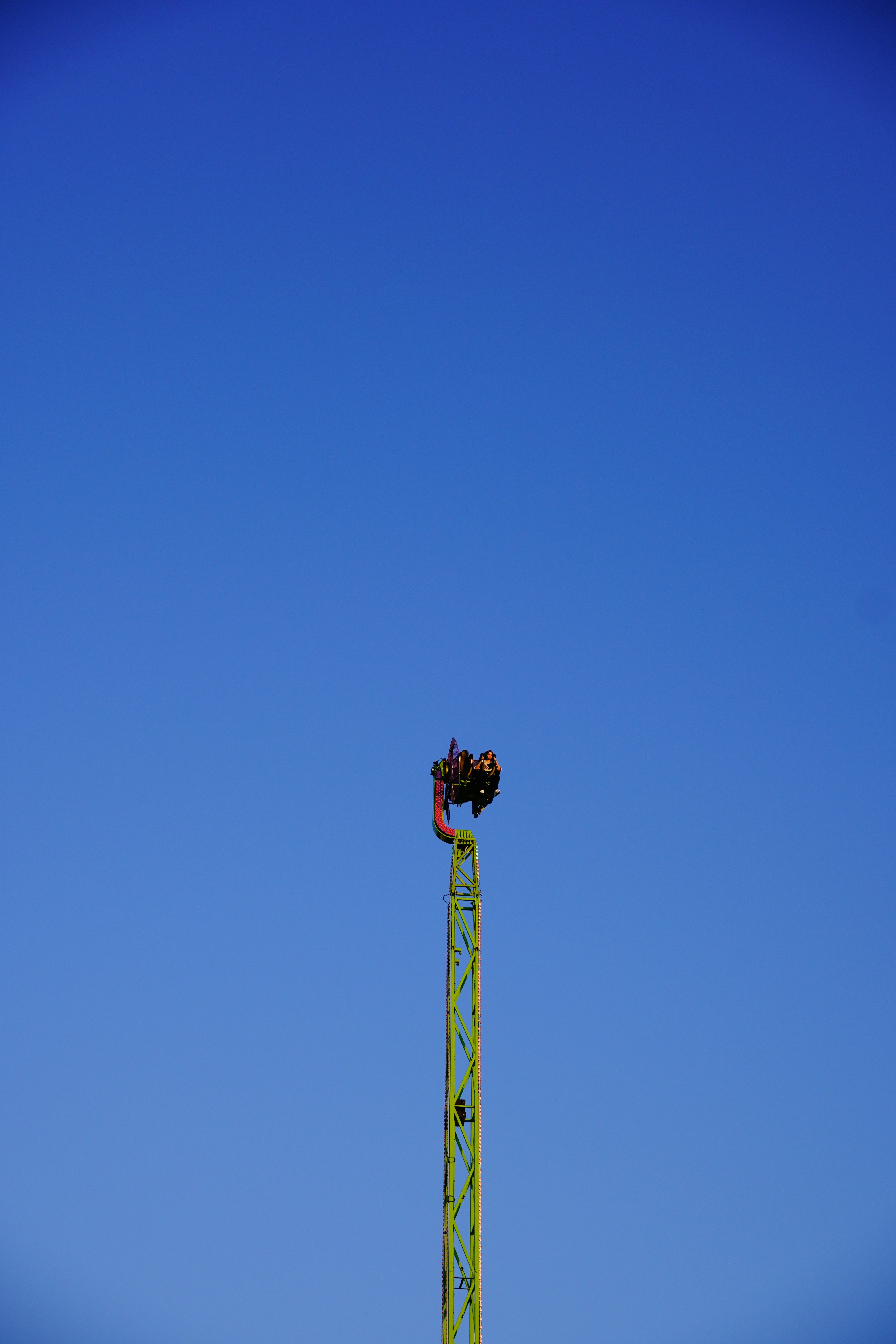 High-Altitude Thrill: Riders at the Crown of a Lifting Structure