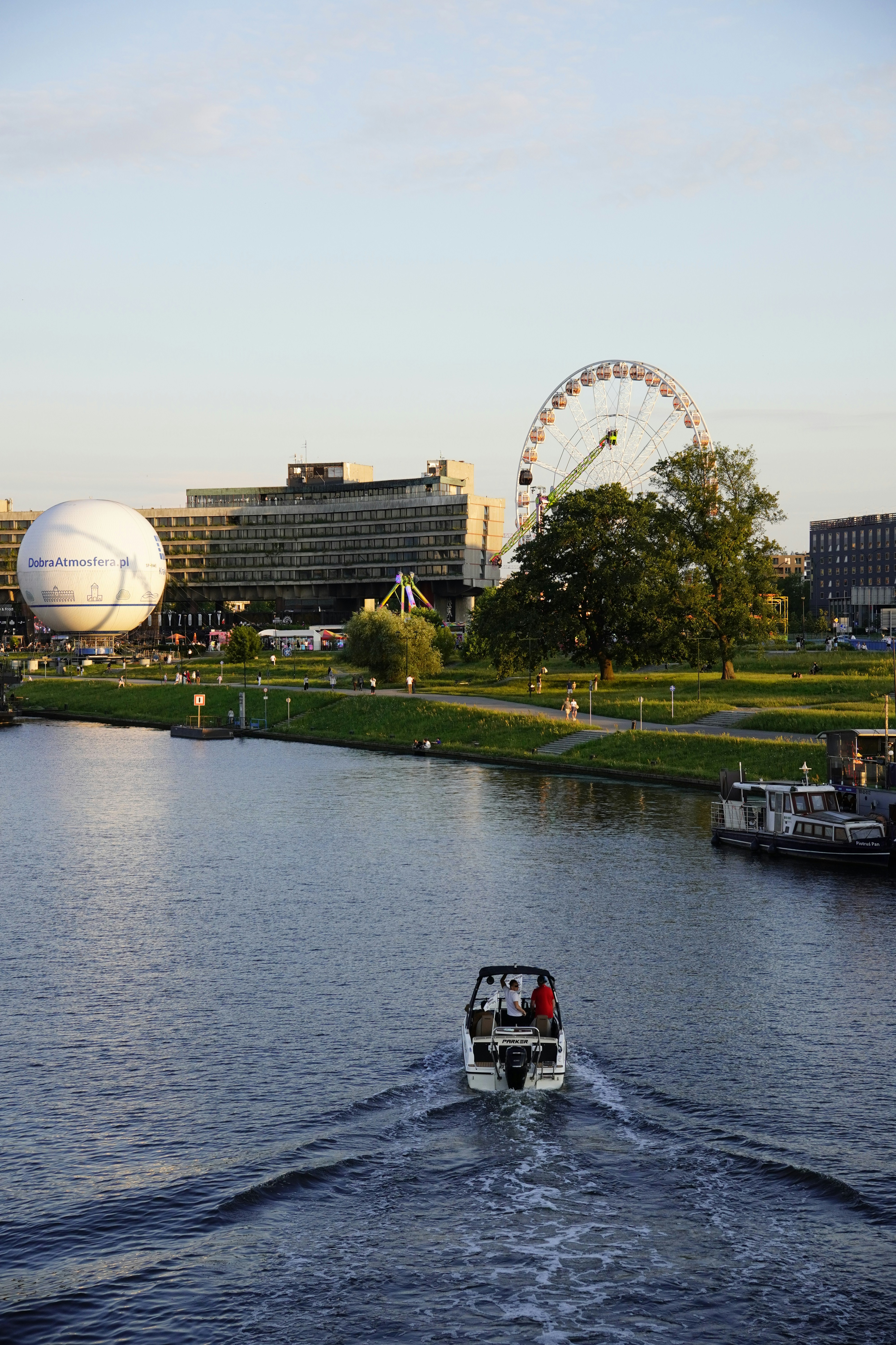 Waterway Vista: Boat Wake Toward the City Park and Ferris Wheel