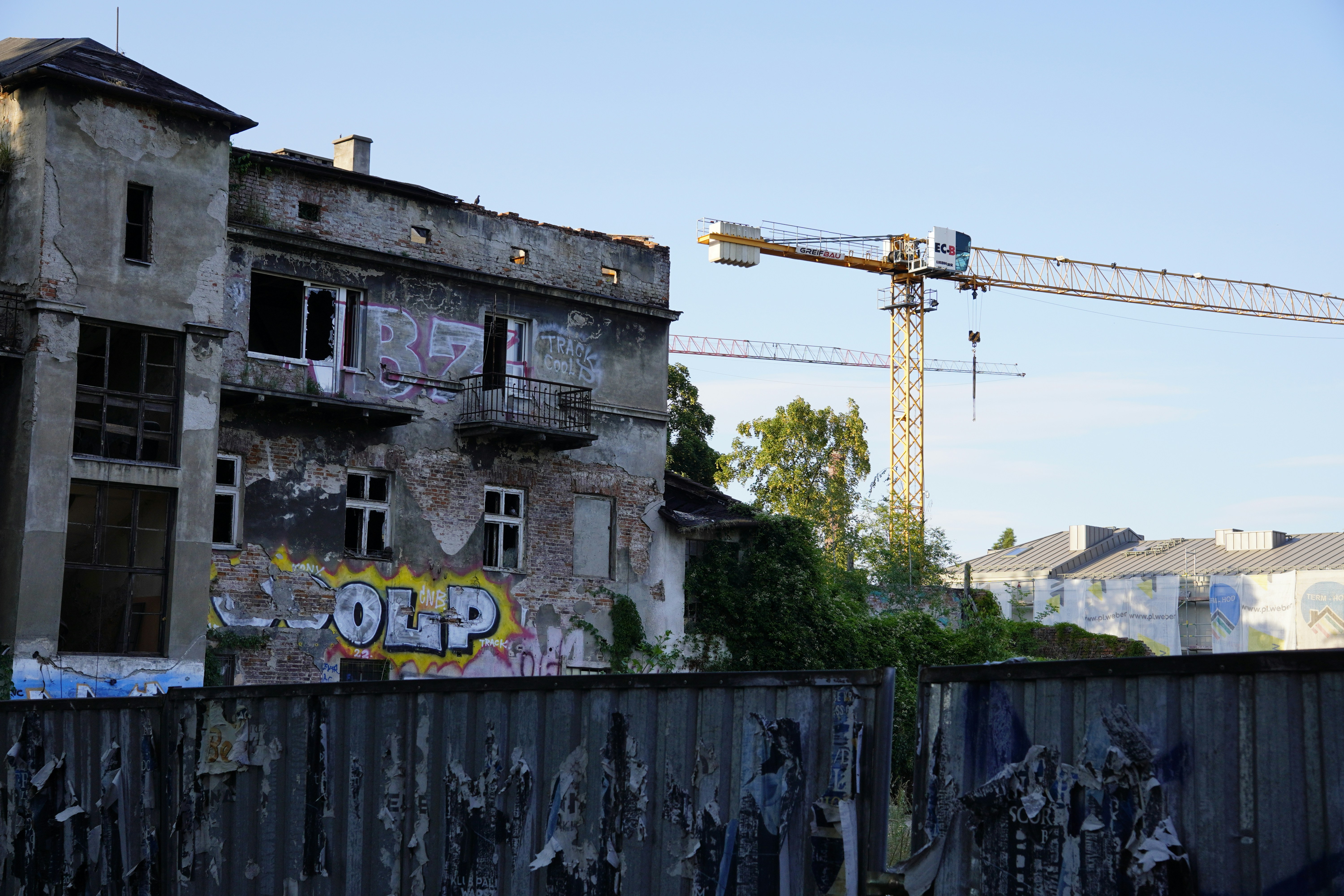 Crumbling Factory Facade with Graffiti and Skyline Crane