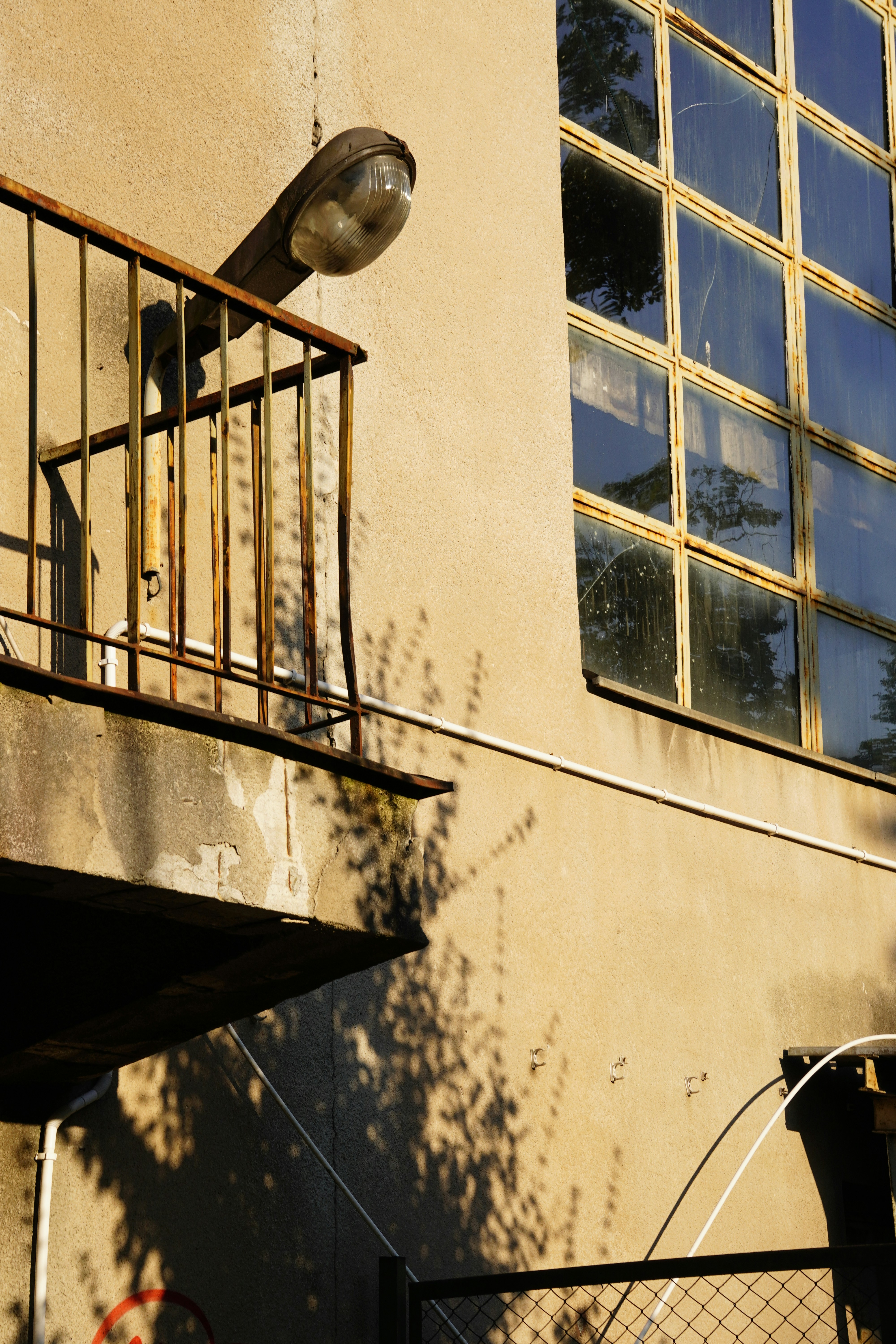 Sunlit Facade with Industrial Balcony and Large Window Grid