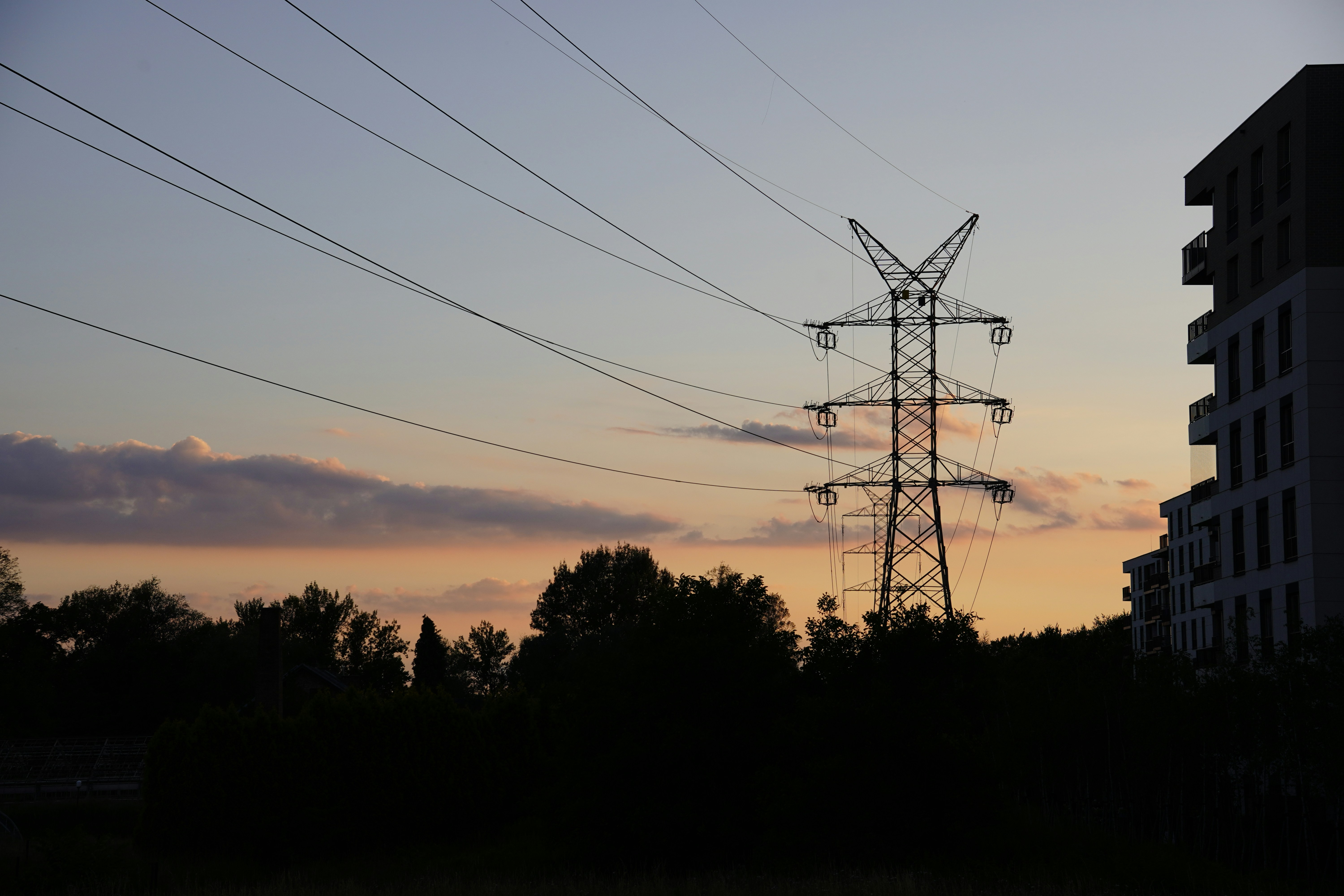Sunset Skyline: Power Lines Against a Dusk-hued Horizon