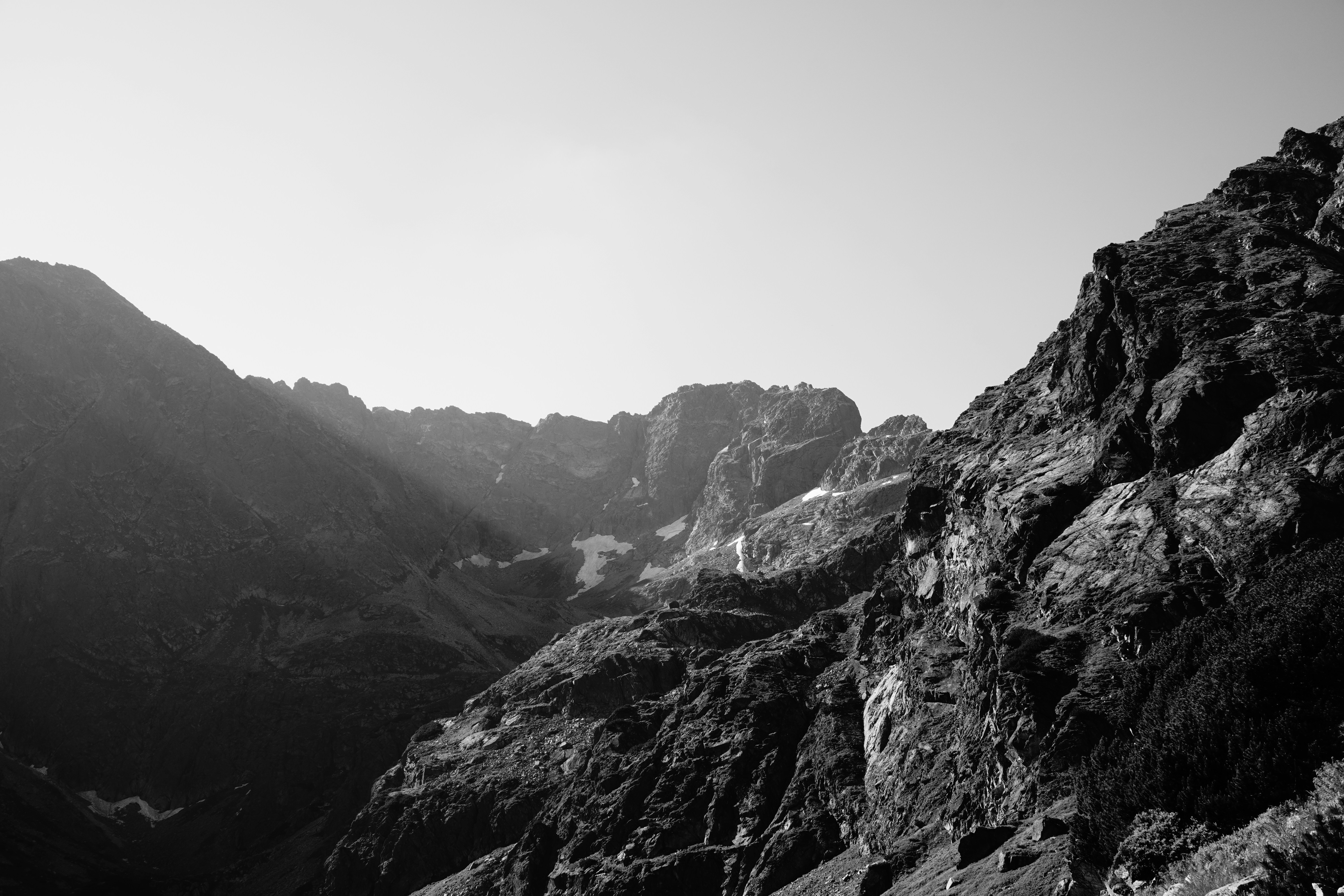 Rugged Alpine Rim: Sunlit Prominence Over Jagged Peaks