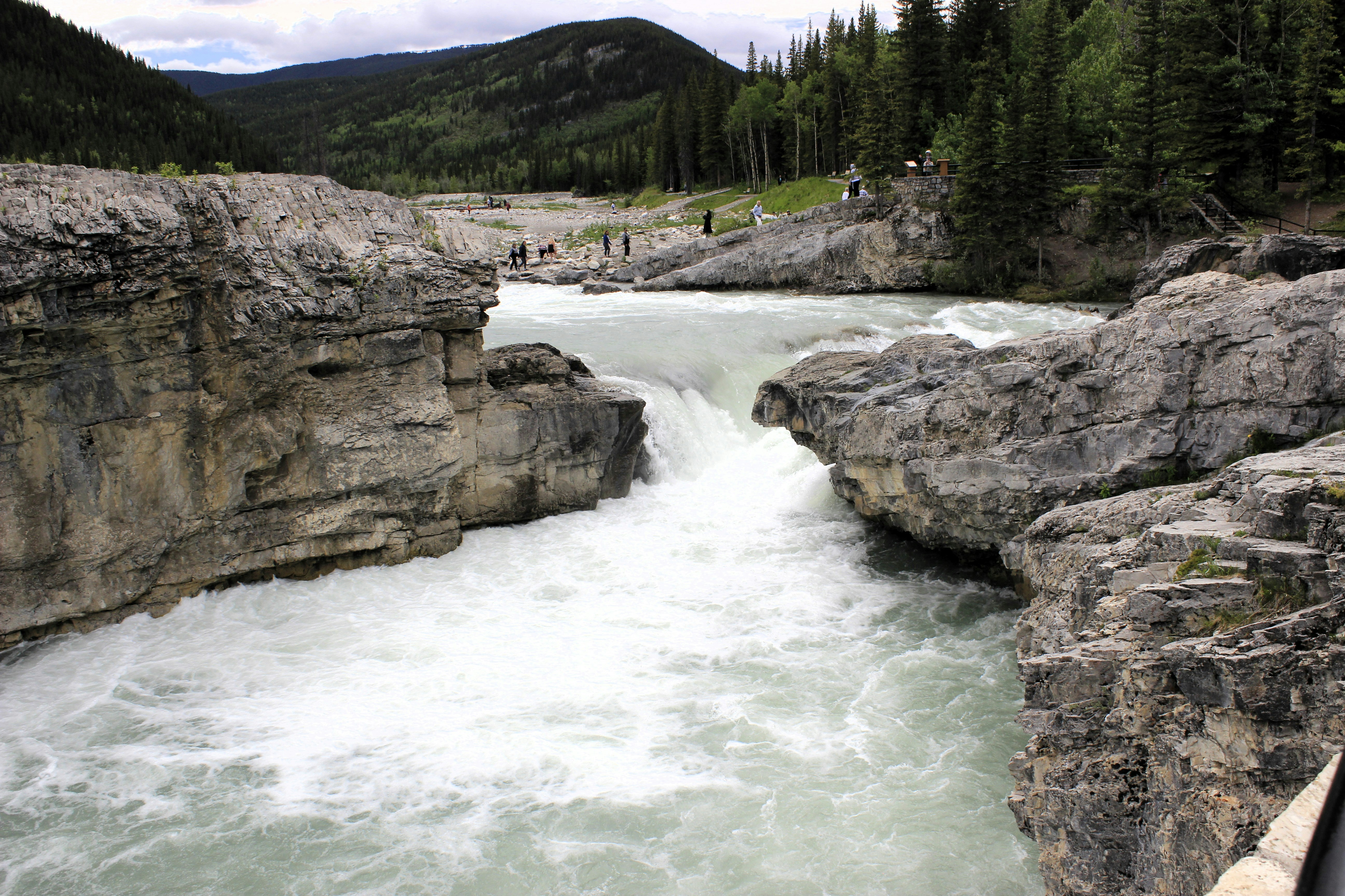 Rugged Gorge Confluence as River Surges Between Weathered Cliffs