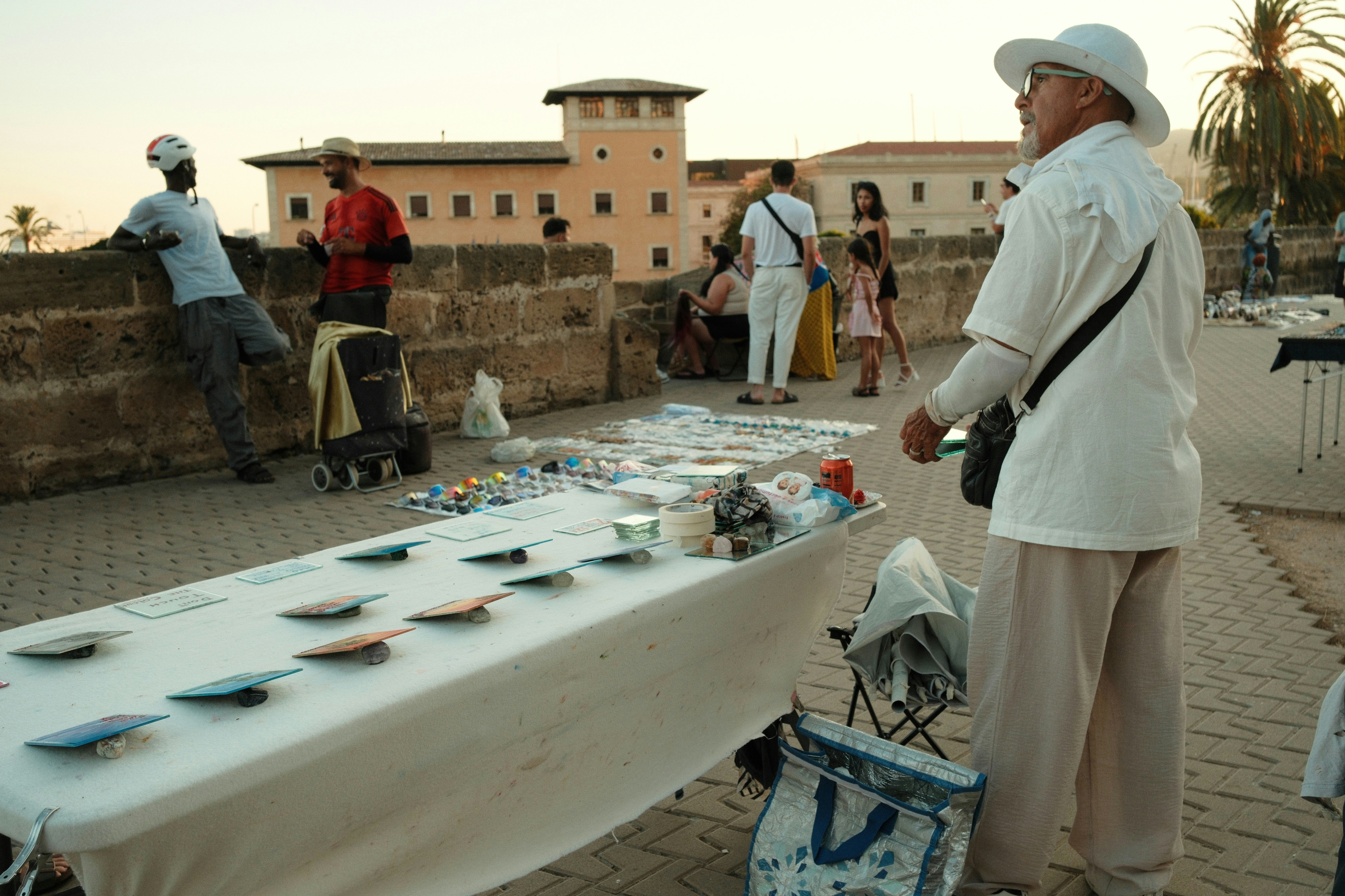 Sunlit Market on the Rampart: Artisans, Tourists, and a White-Suited Sentinel