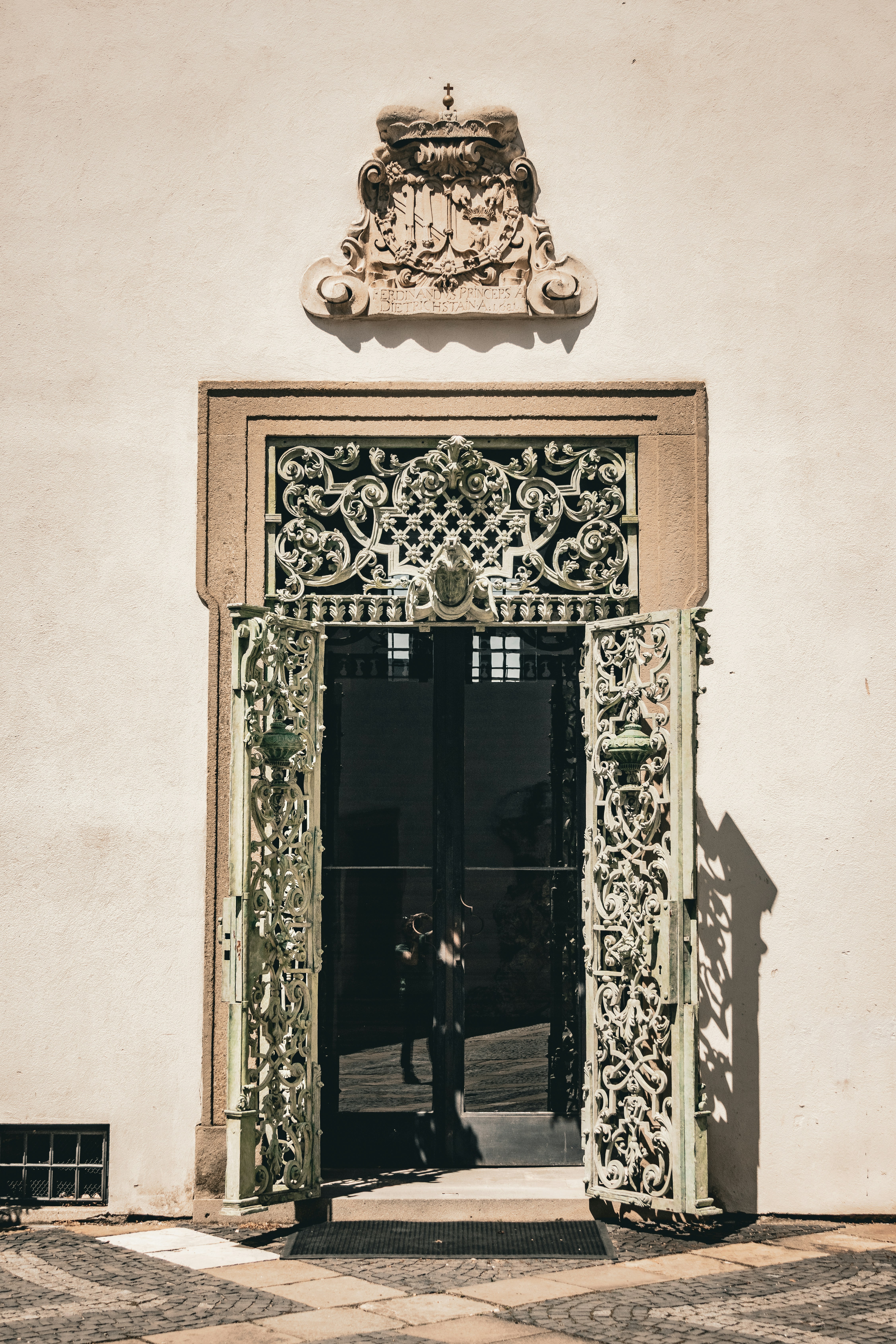 Ornate Gate in Soft Light: A Quiet Opening to a Shadowed Interior