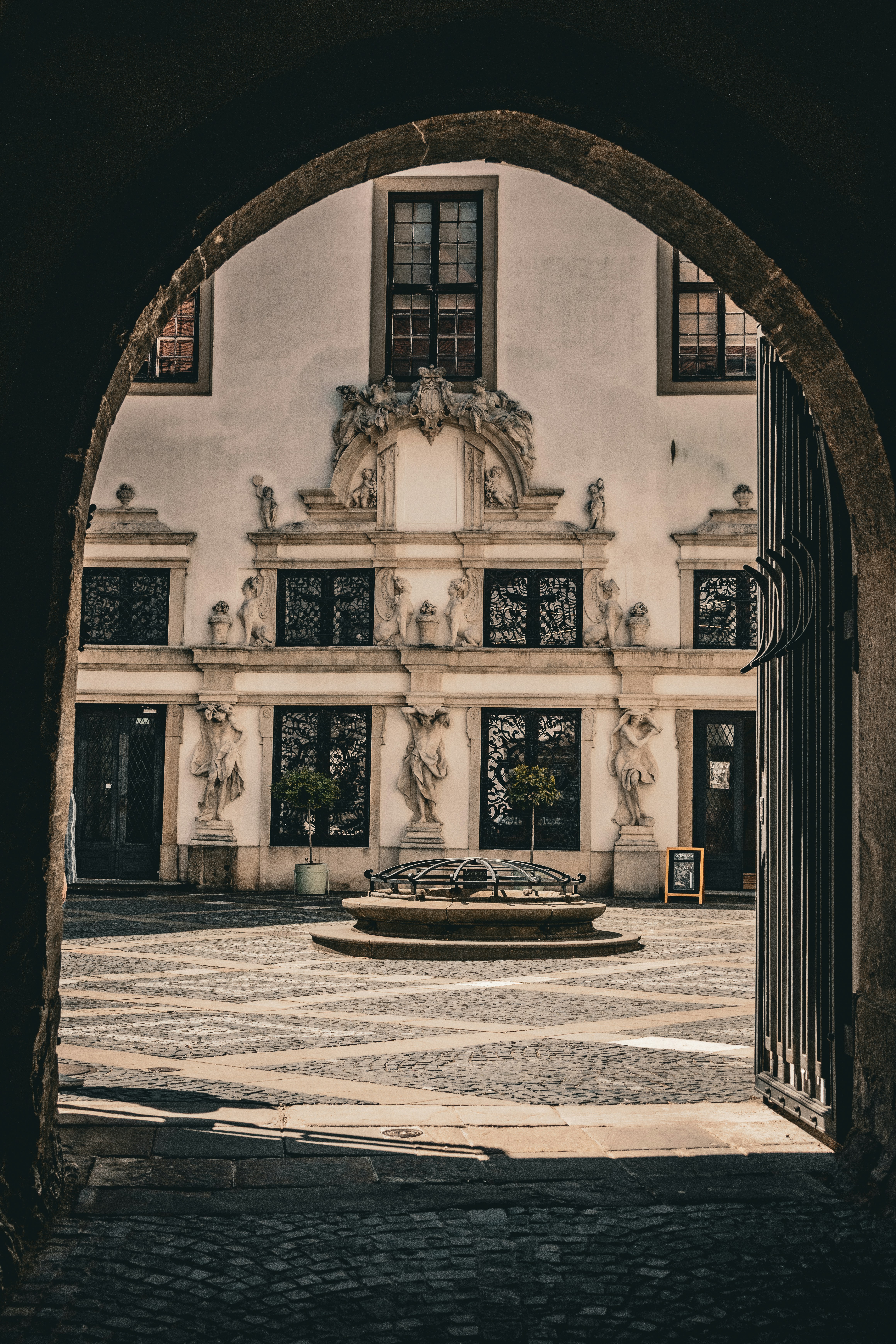 Through the Arch: A Baroque Courtyard Framed by Stone and Shadow