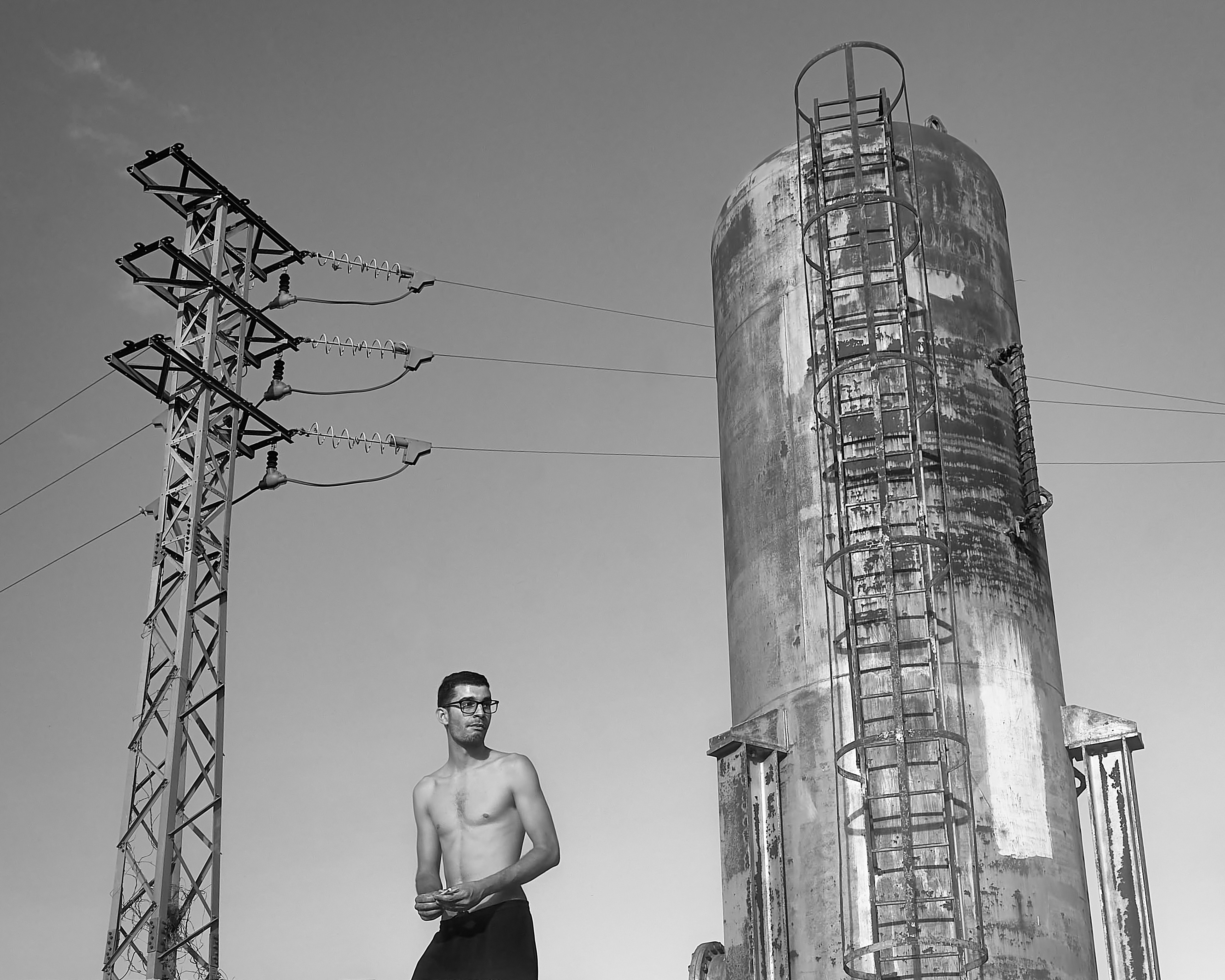 Man at the Edge of Industry: A Quiet Moment by the Tank