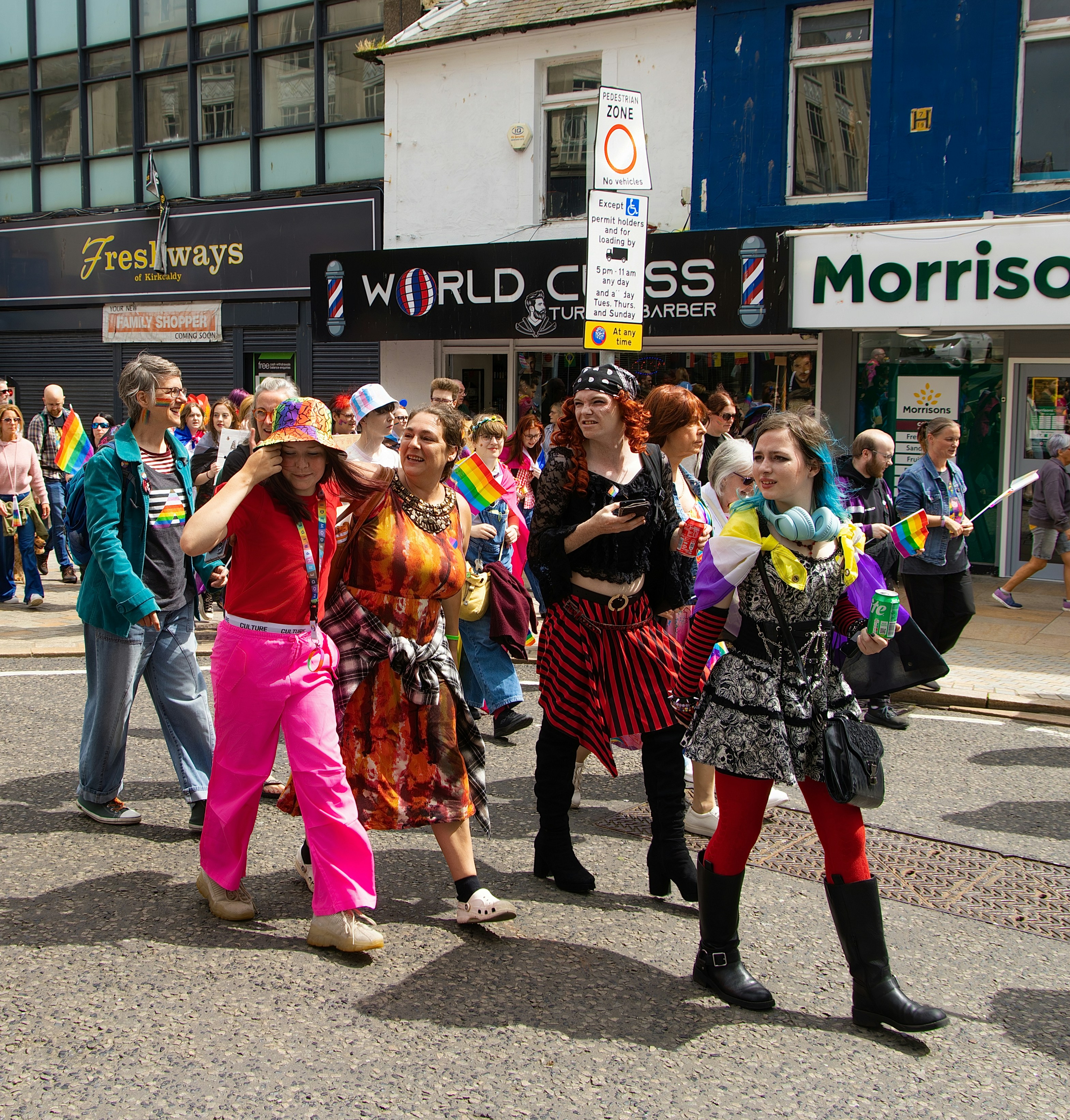 Colorful parade in front of a barber shop under a World Cup sign