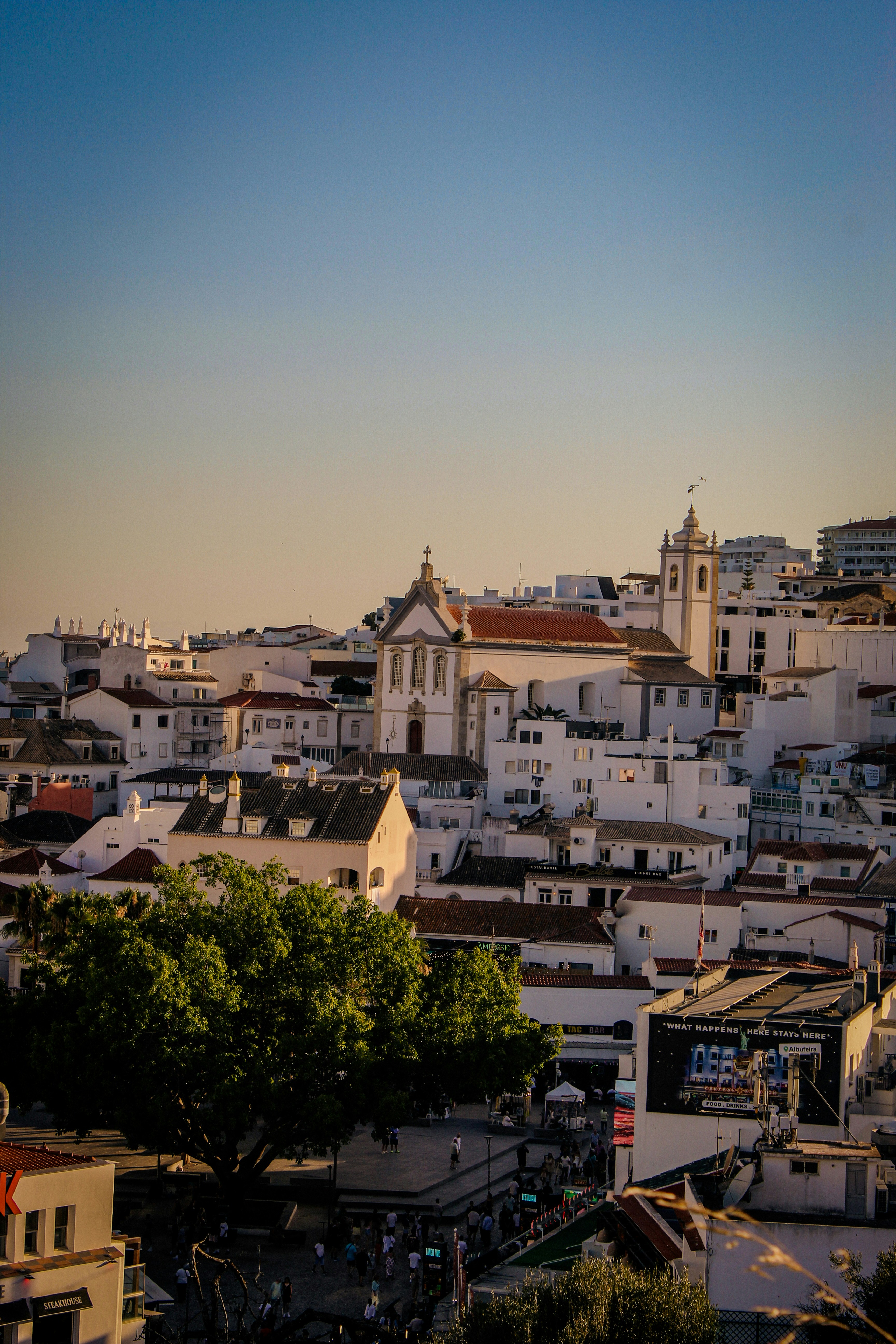 White-town Terrace: A Sunlit Panorama of Quiet Rooftops and a Framed Church