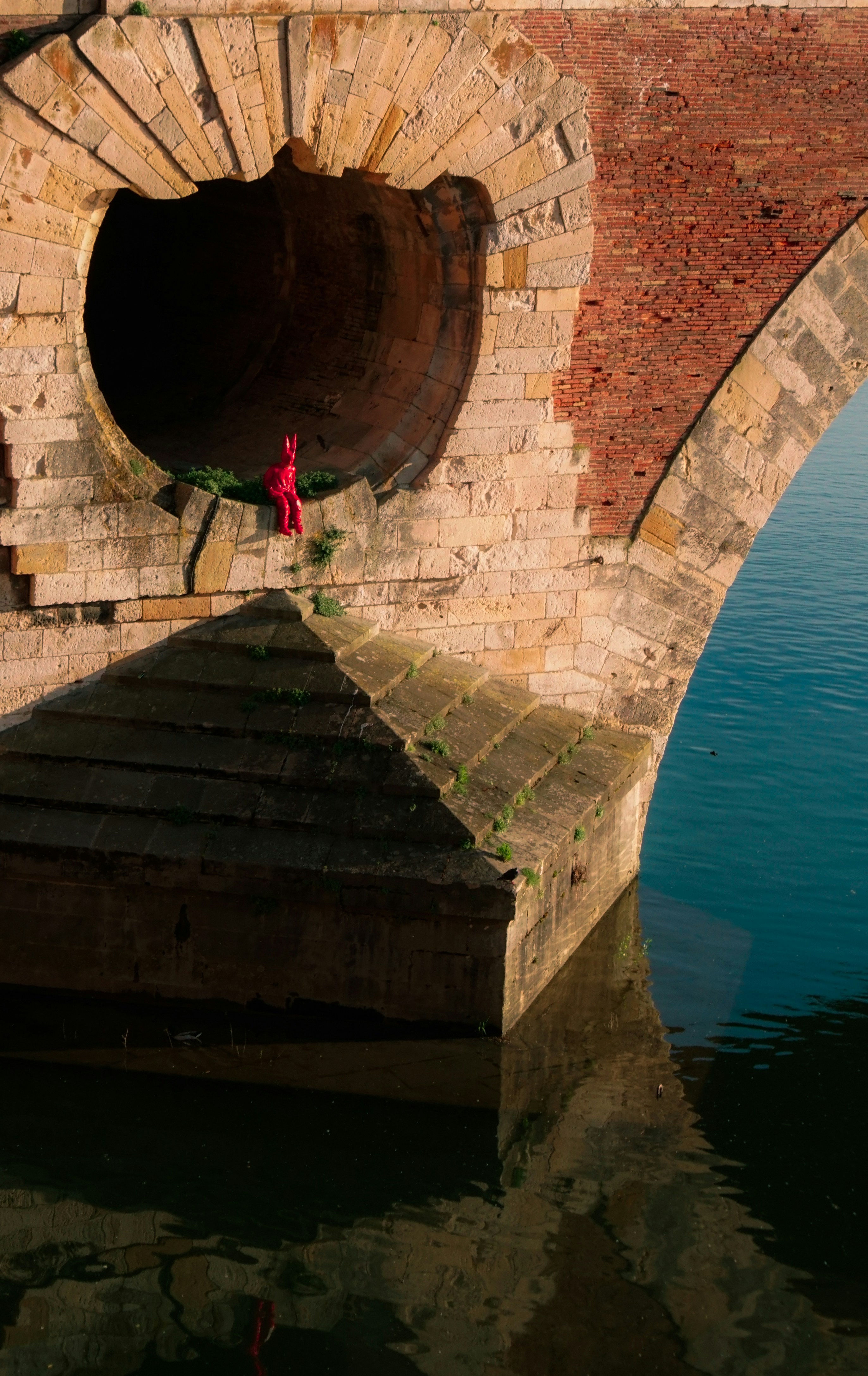Bold Red Figure at the Circular Portal