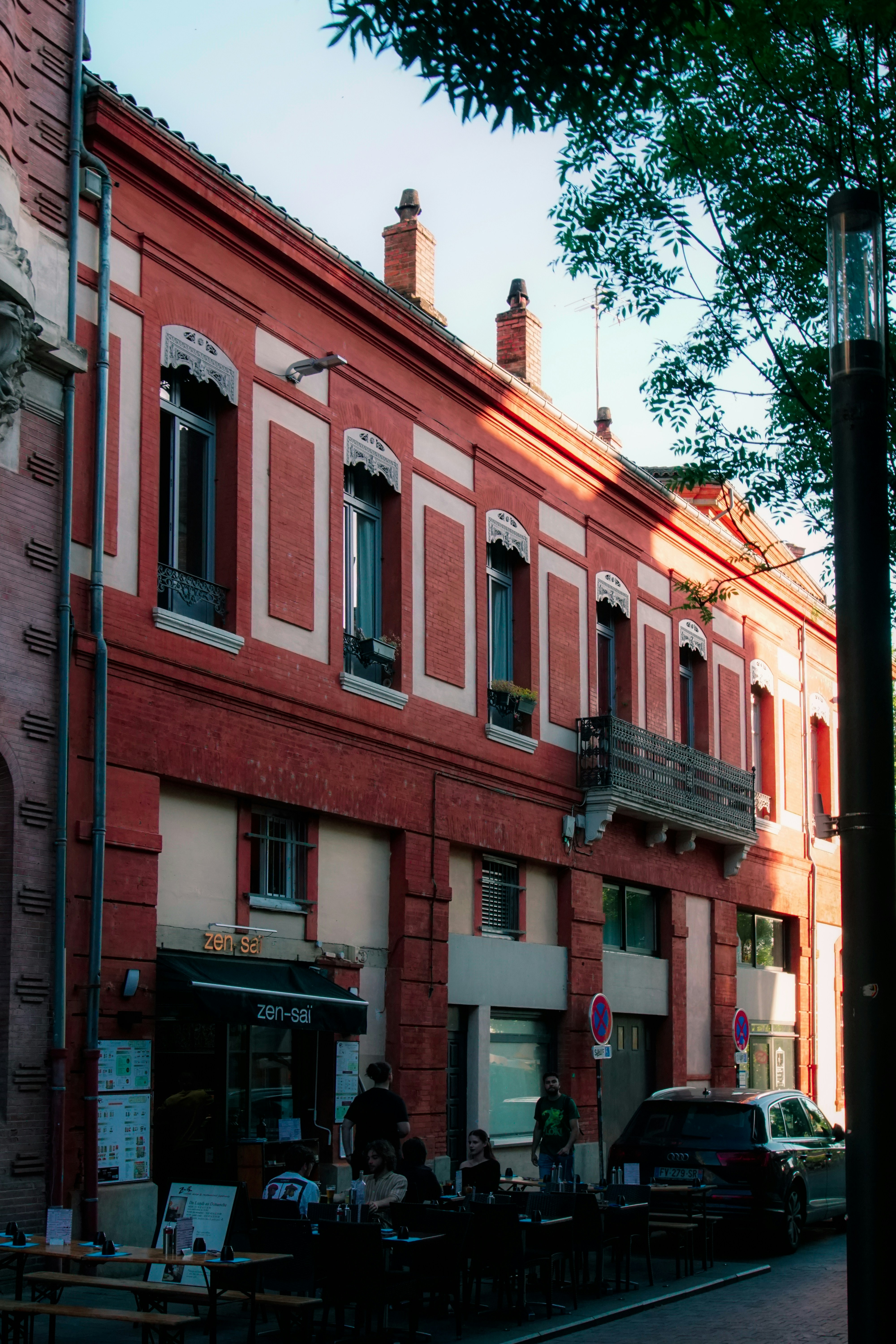 Red Brick Street Morning: Sunlit Facades and Café Vibe
