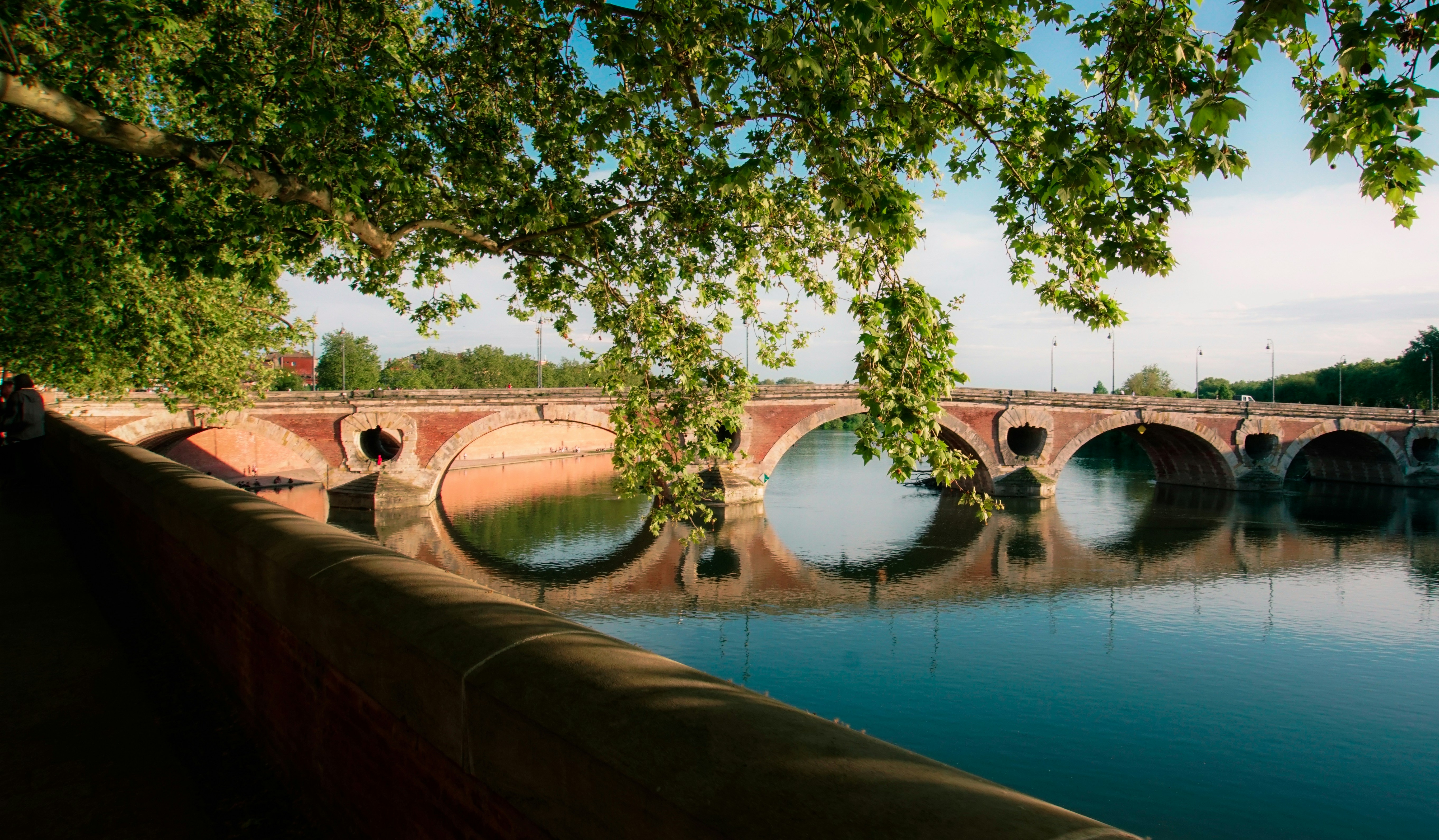 Sunlit Arcades: Riverside Bridge Reflections