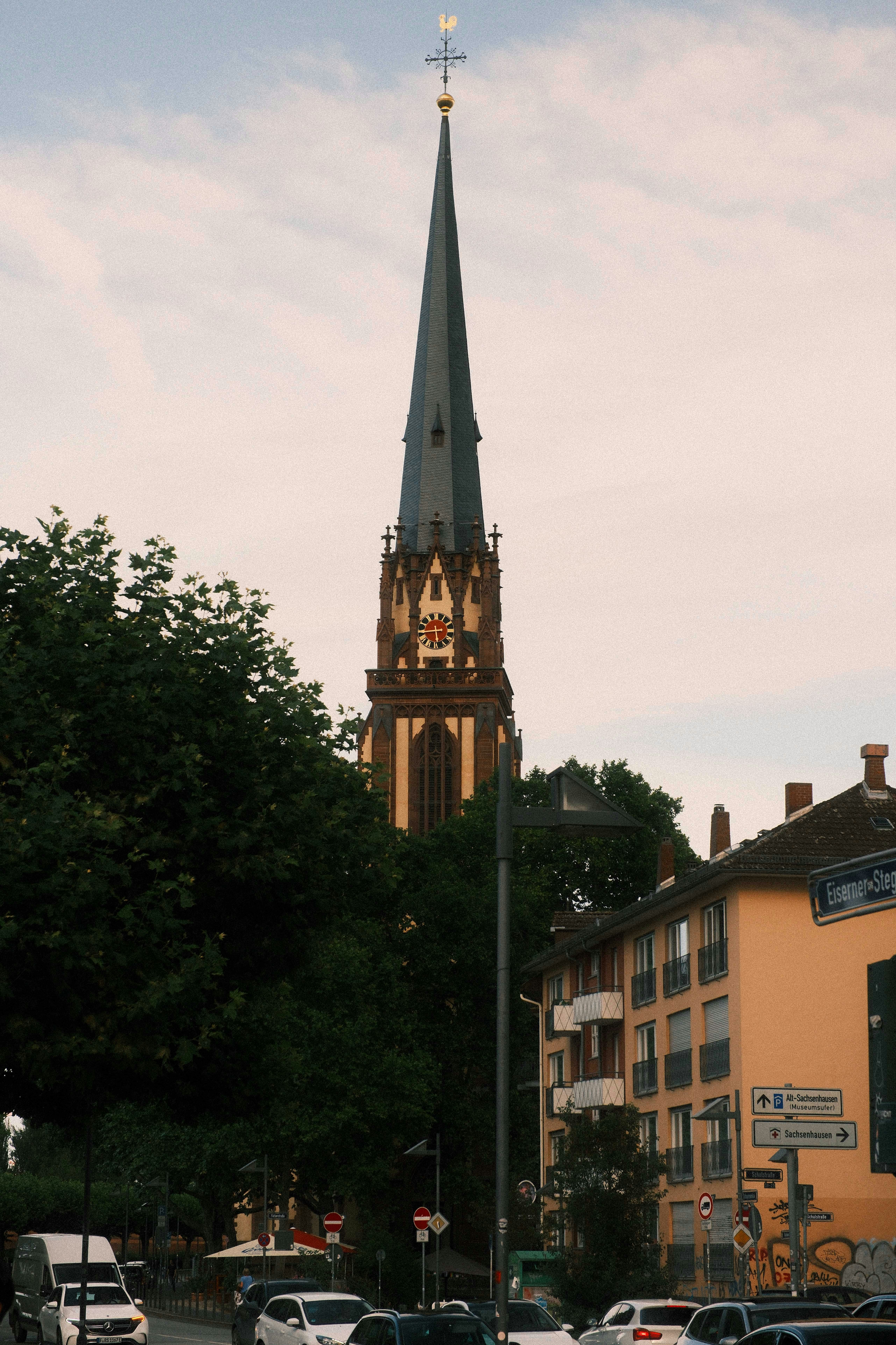 Stately church spire rising above a sunlit streetscape