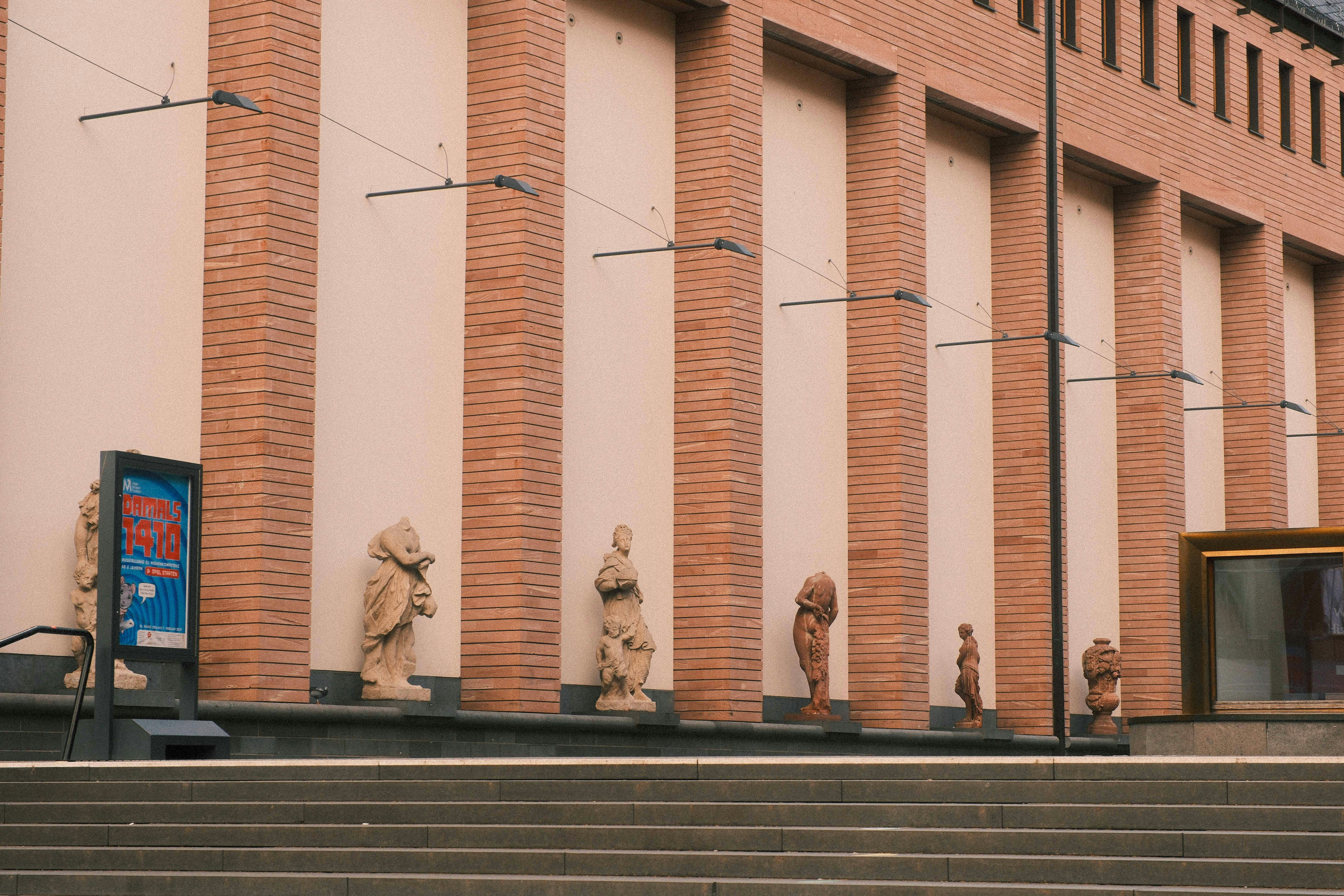 Statues watching over the steps: a facade of arches and shadows