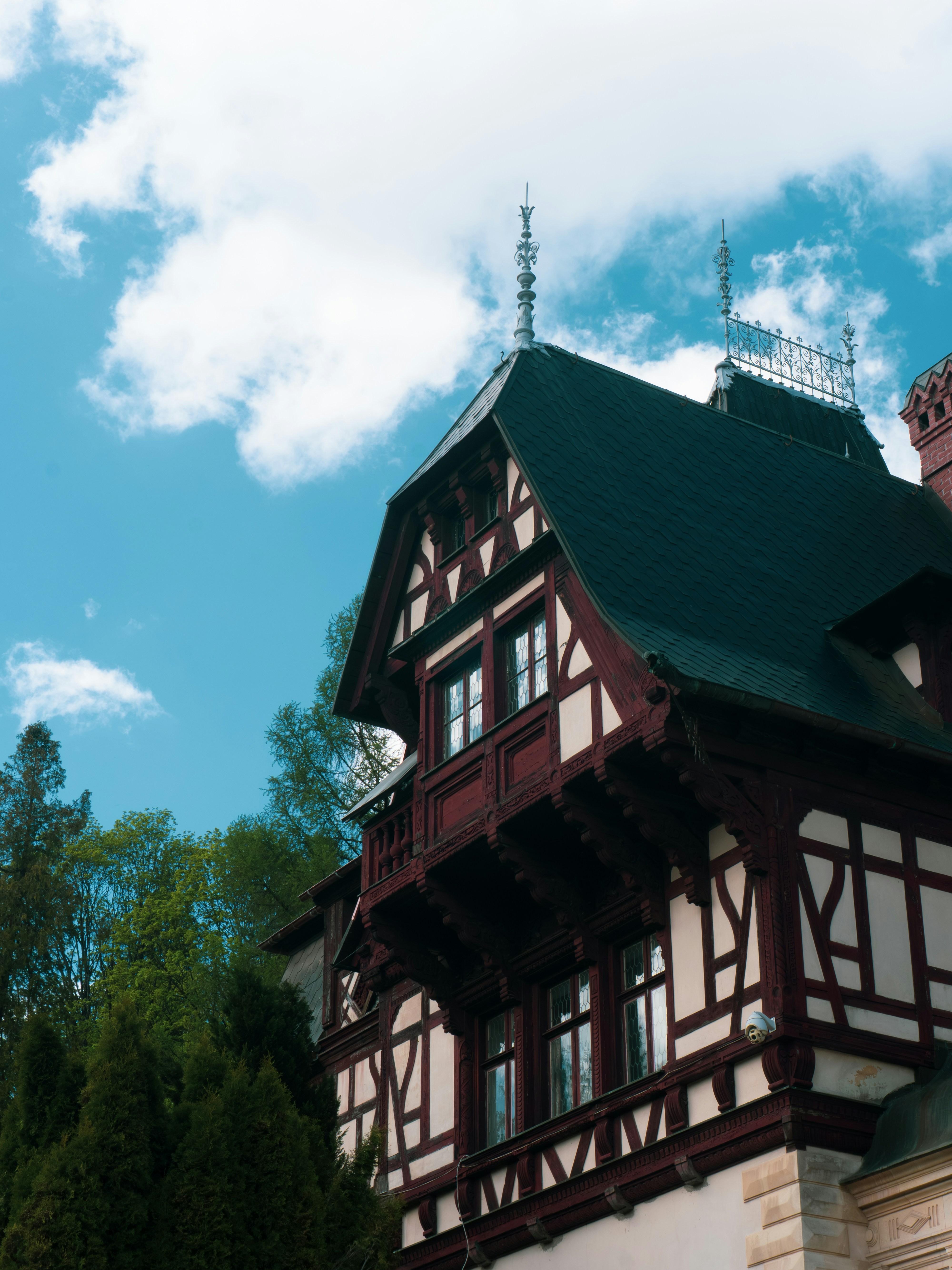 Timbered Roofline Crowned with Spires Against a Clear Blue Sky