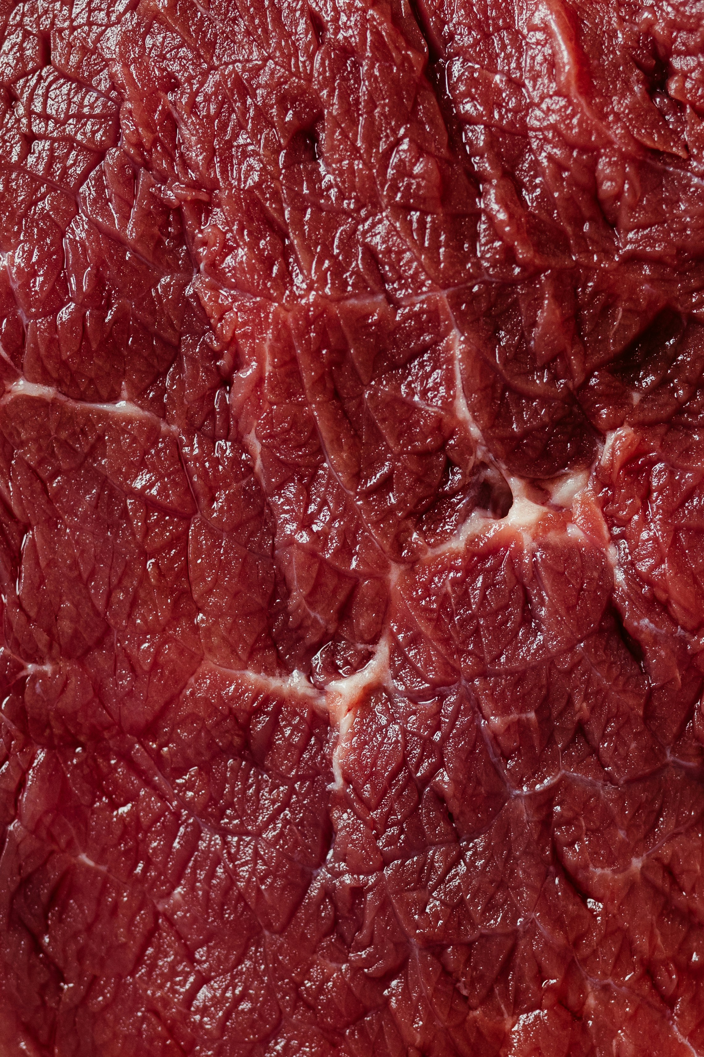 Crimson Texture: A Macro Slice of Raw Red Meat