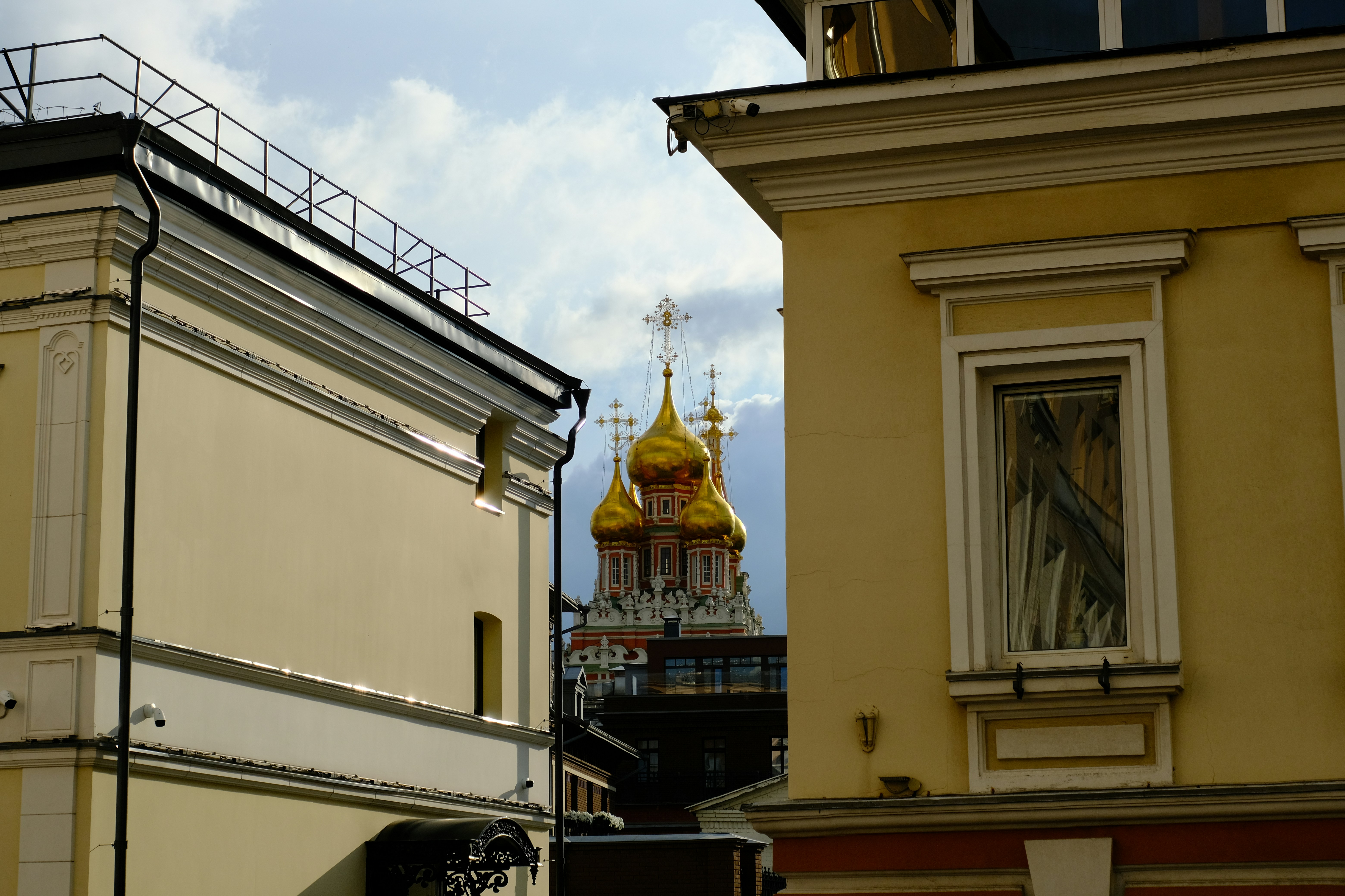 Golden-domed church framed between pale facades