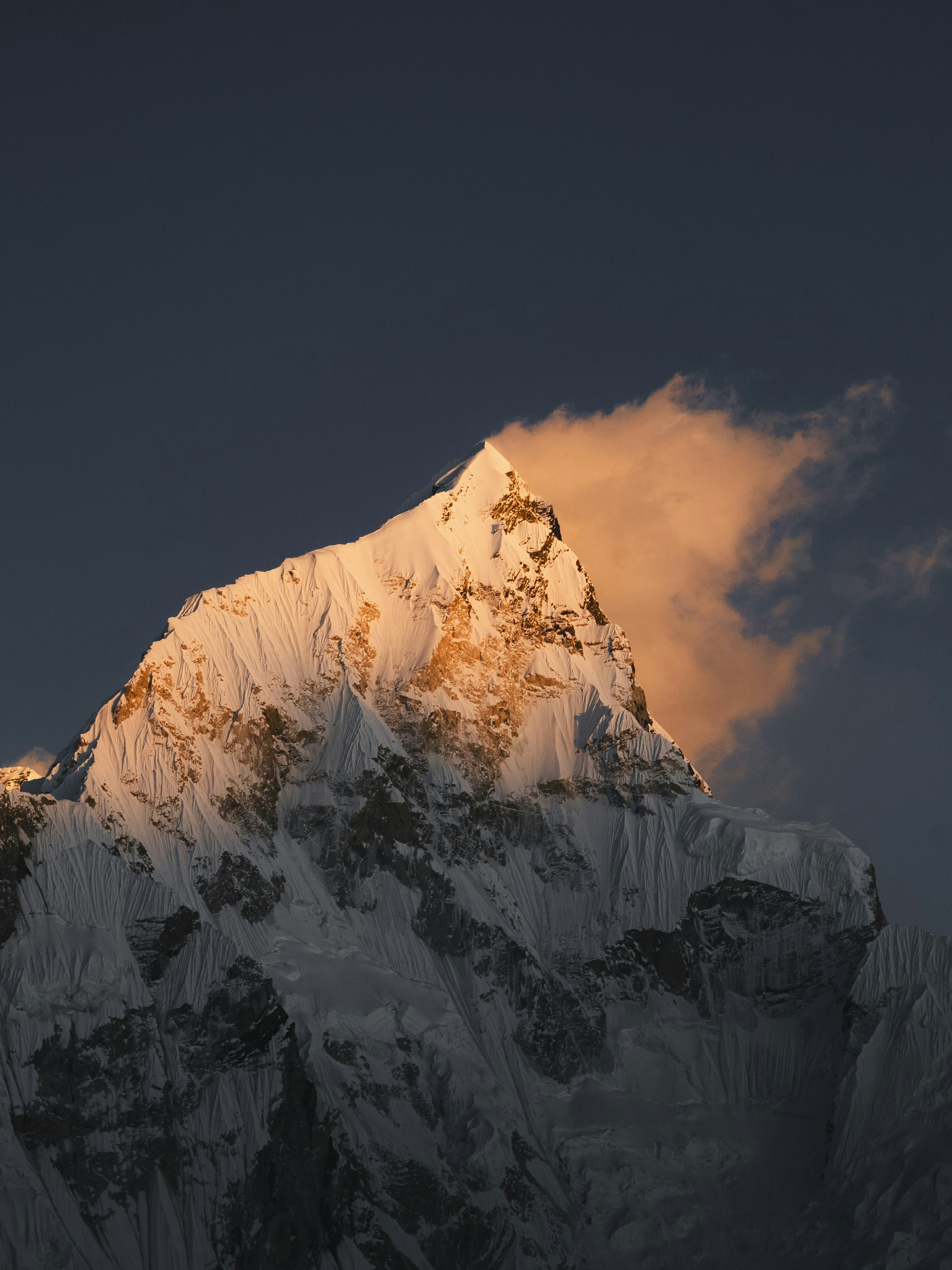 Sunlit Peak: Crown of Ice against a Night Sky
