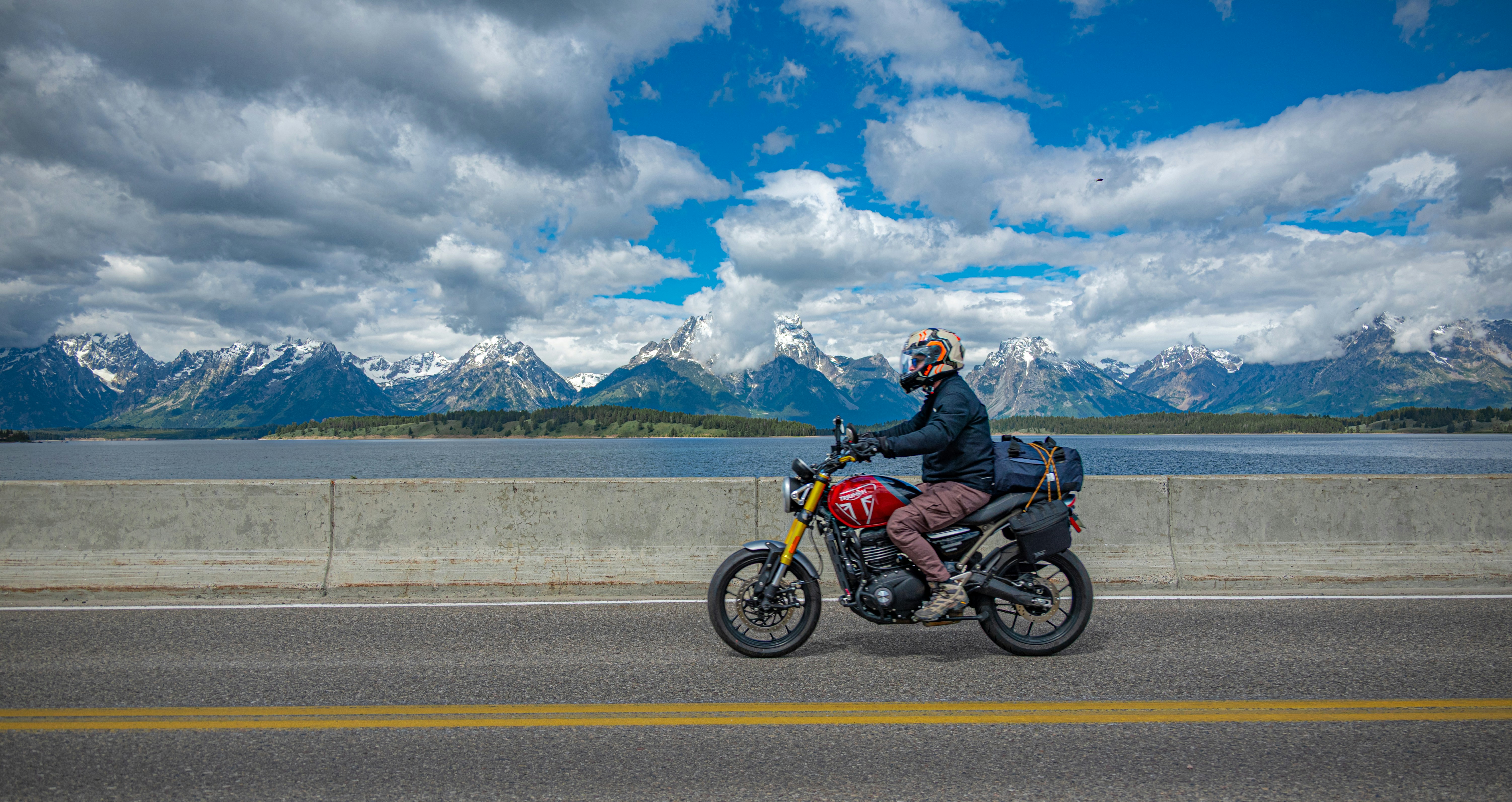 Rider in profile: vintage motorcycle glides along a mountain-guarded highway