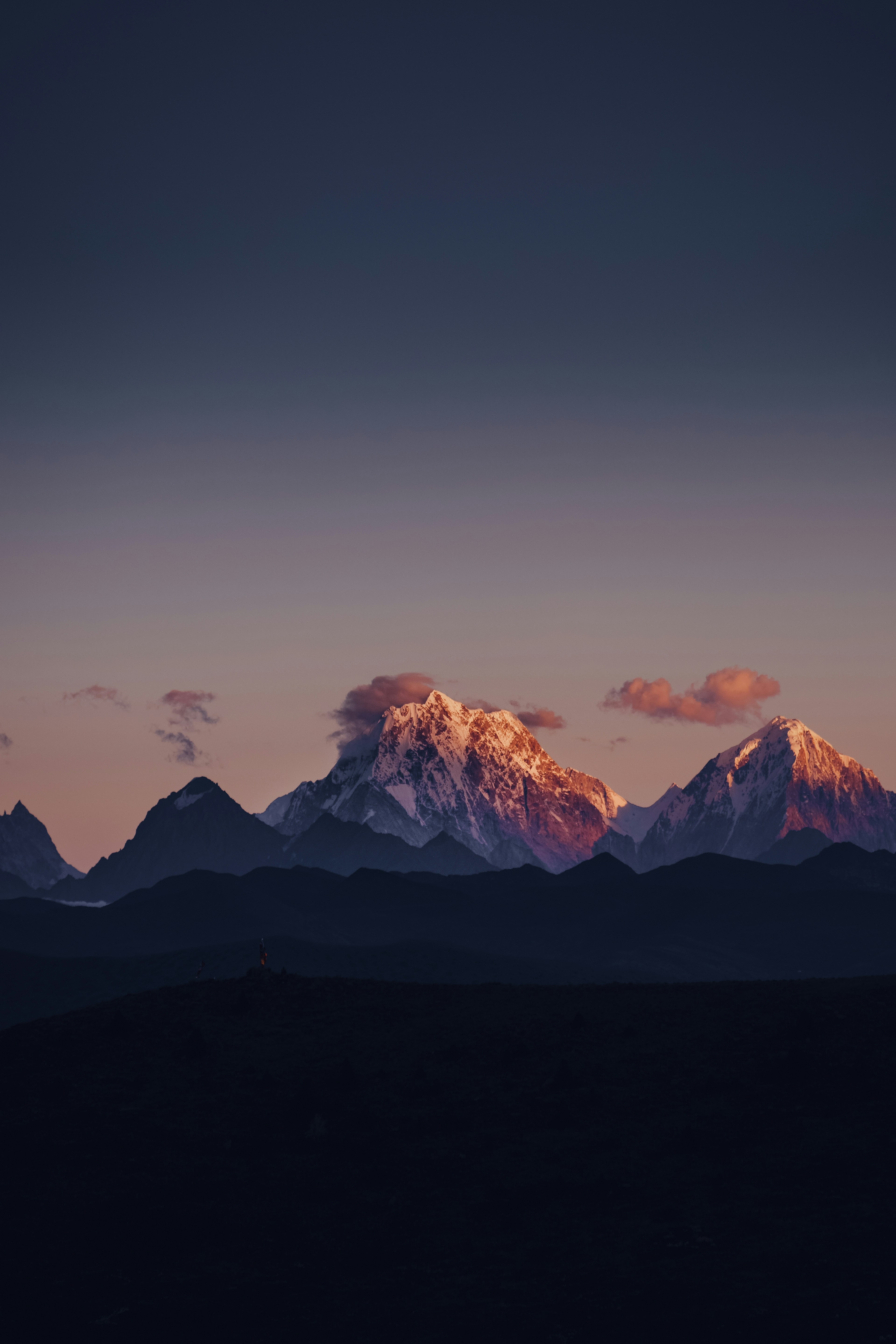Snow-capped mountains illuminated by golden light at sunset.