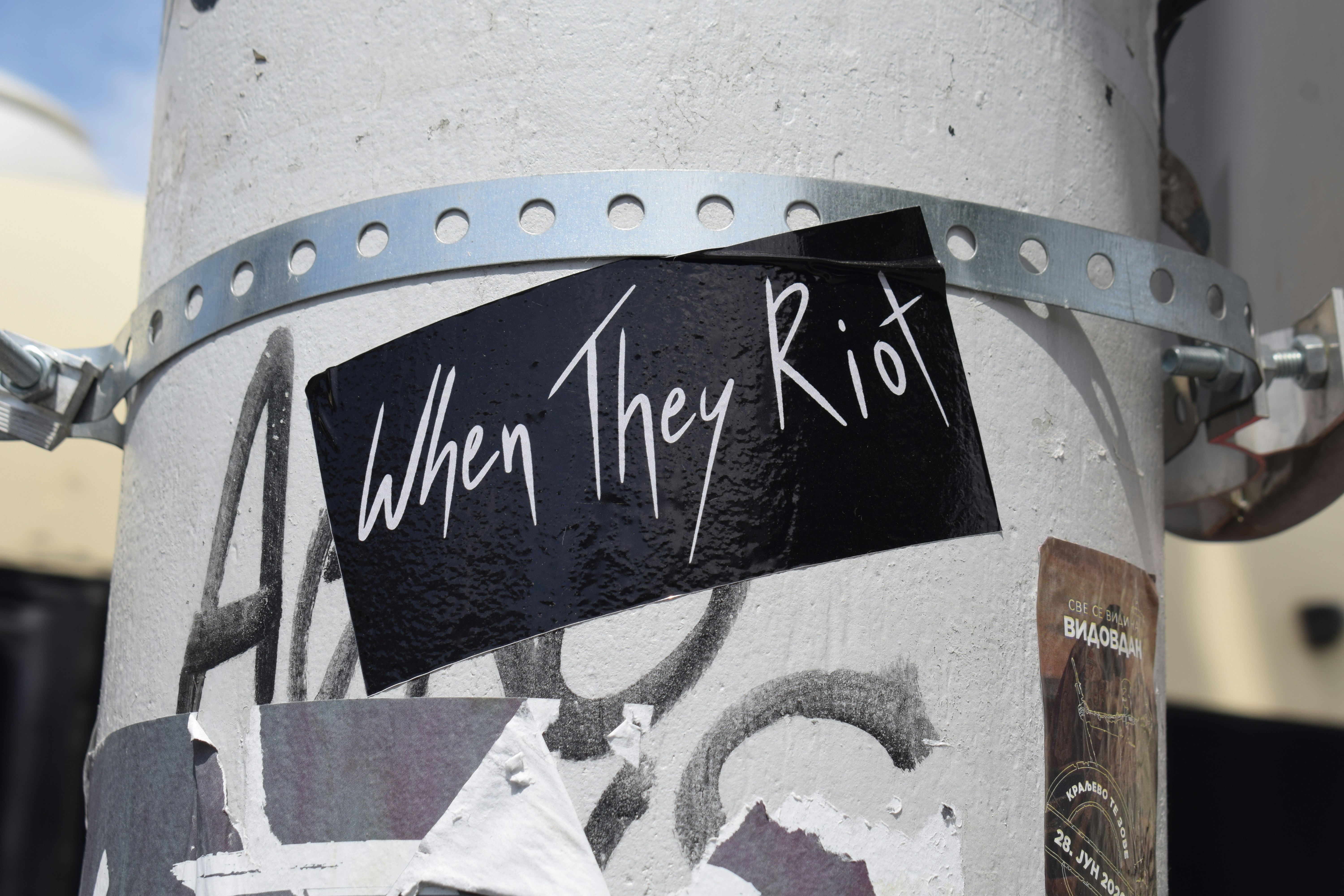 Sticker That Reads 'When They Riot' Clings to a Graffiti-Covered Pole