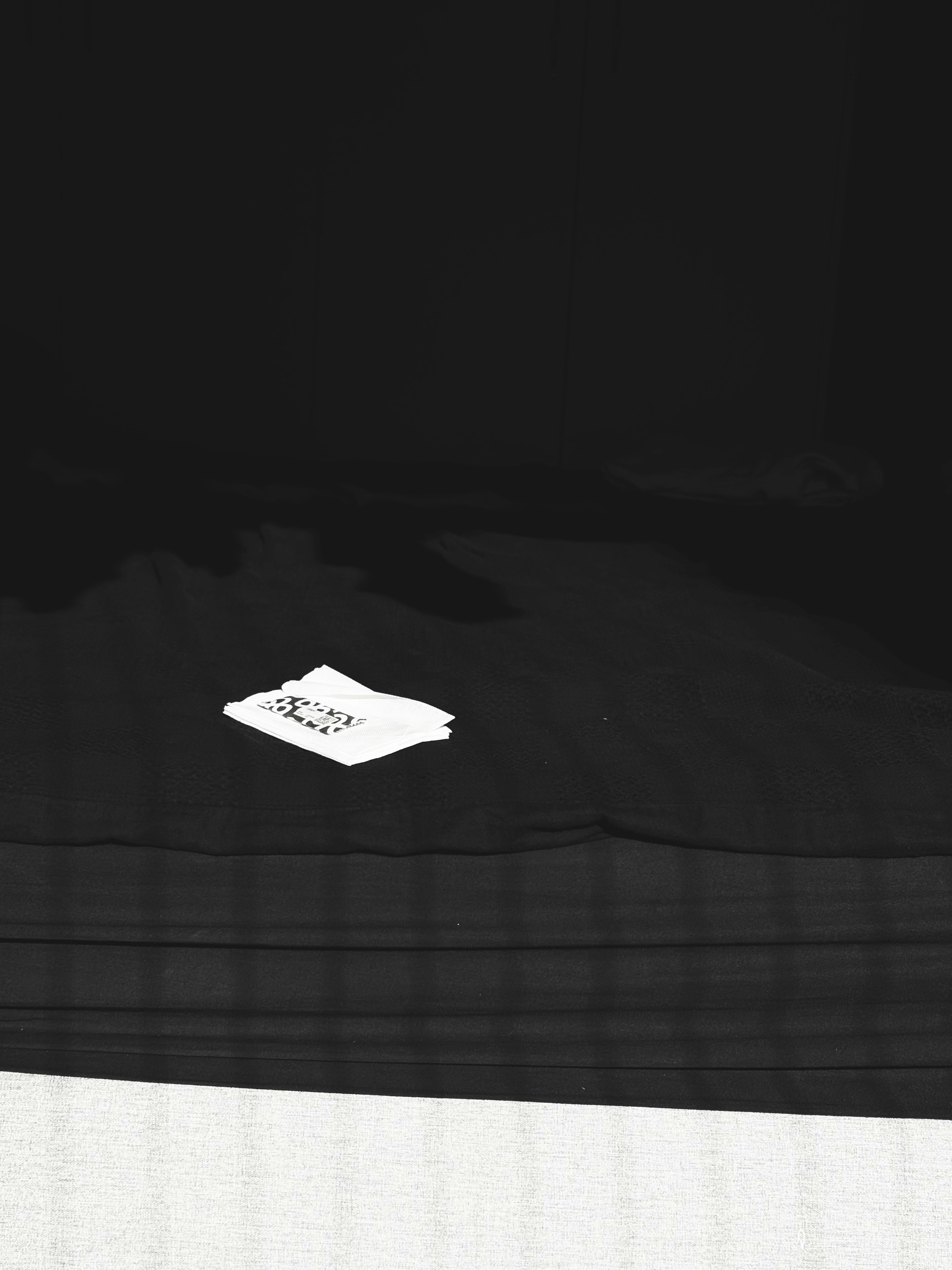 Hidden Tag on a Dark Fold: A Quiet Object Resting on Fabric