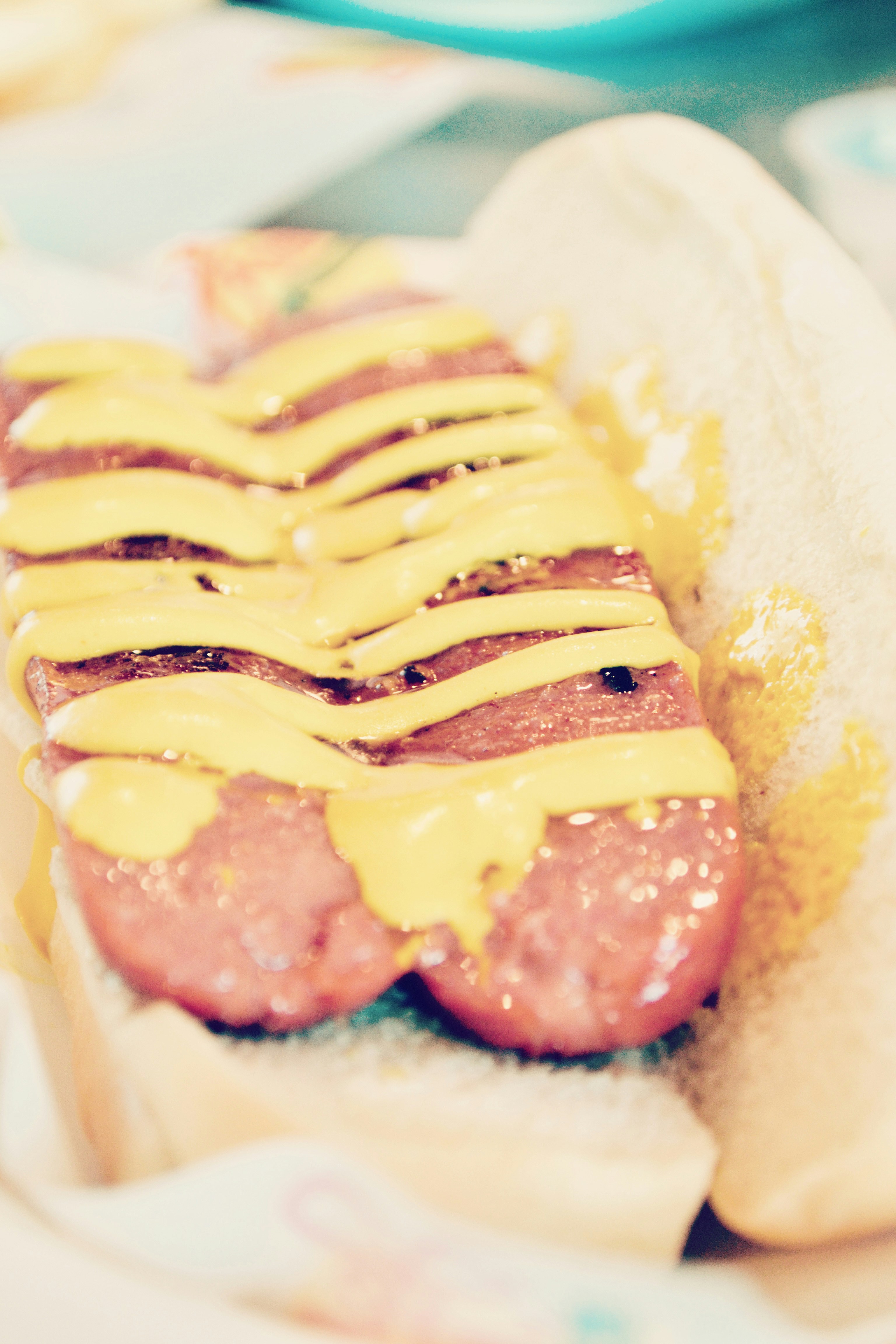 Cheese-drizzled Sausage on a Soft Bun Slice
