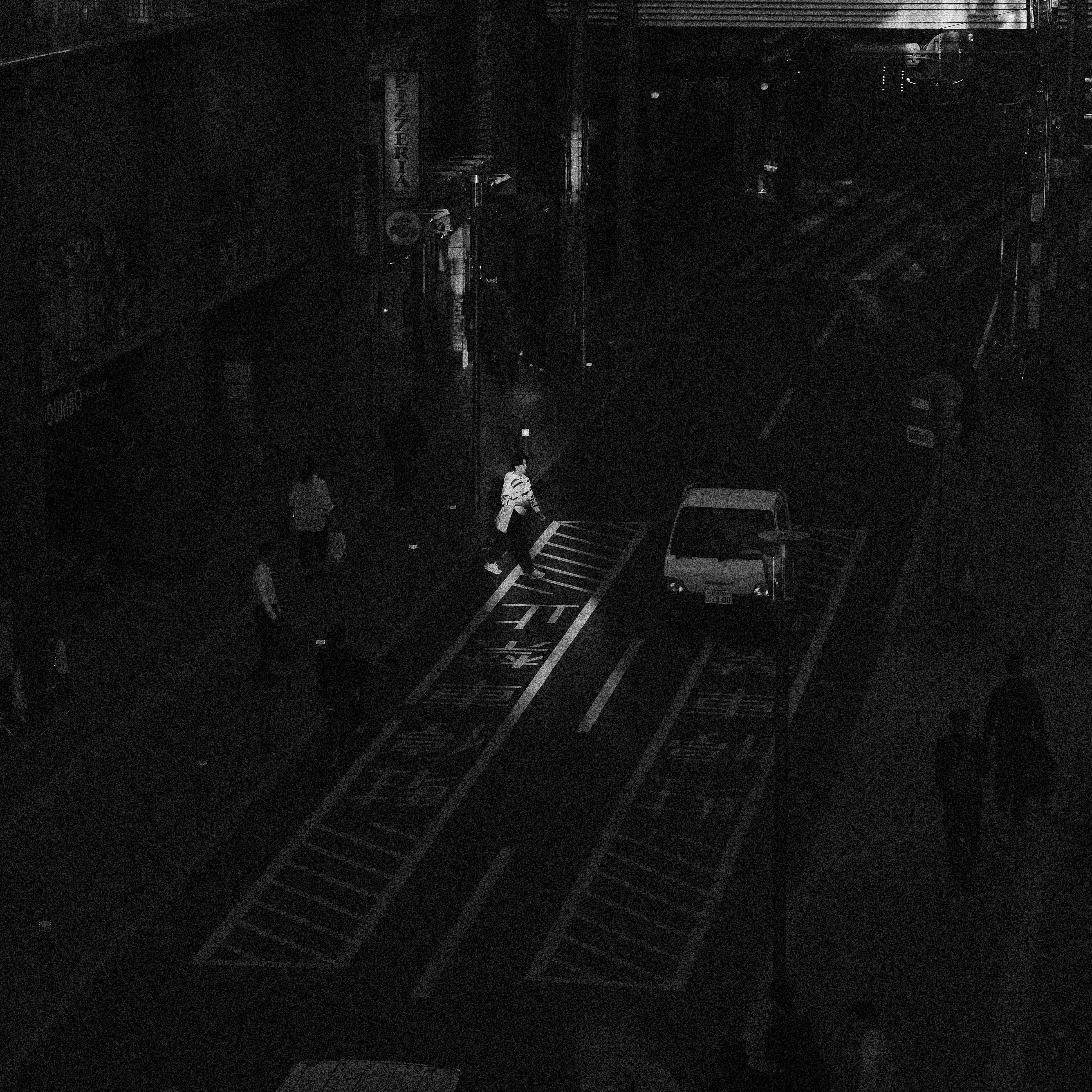 Lone Pedestrian in a Quiet Spotlight on a Night City Street